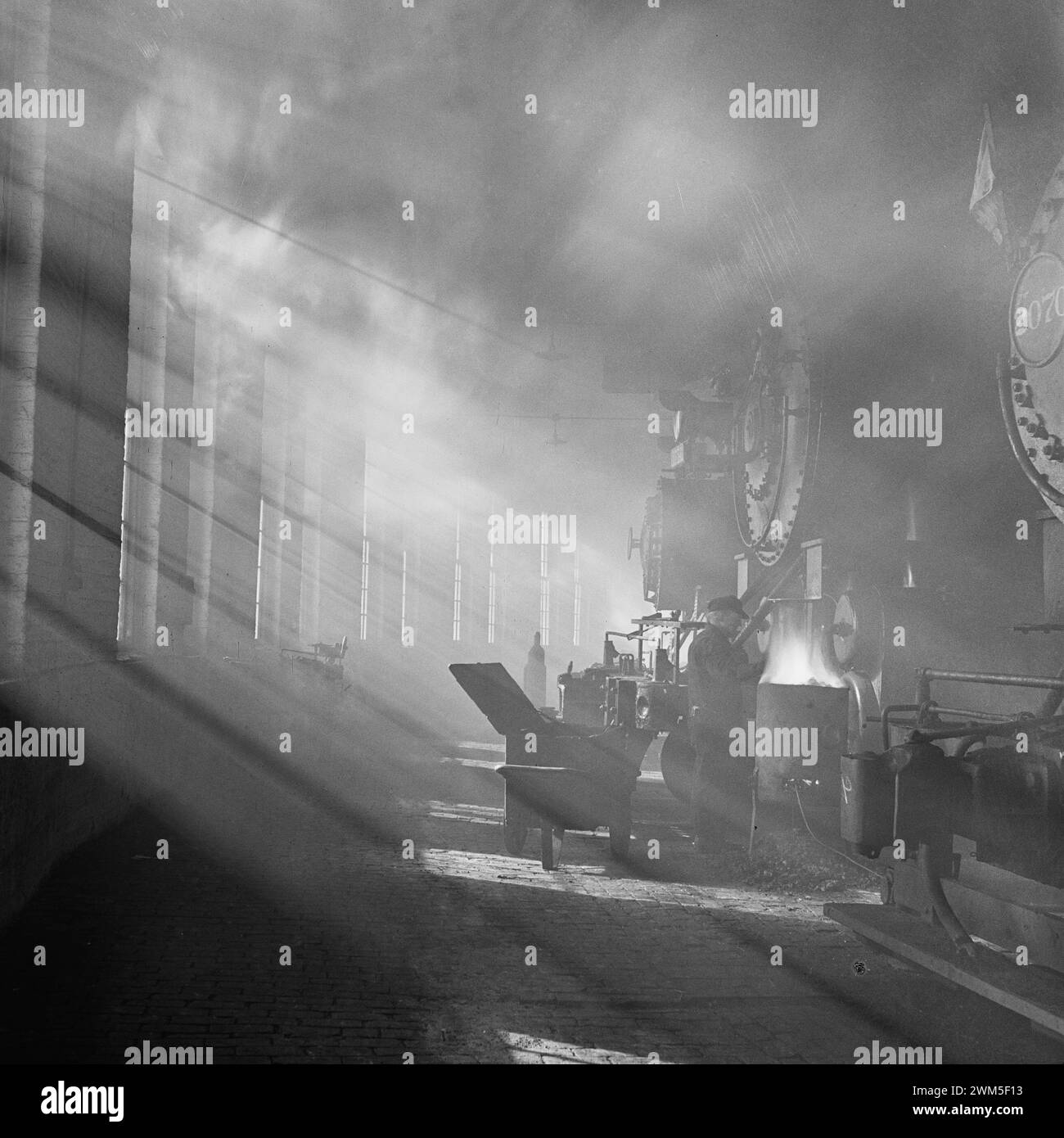 Train worker and locomotives in a beautiful sun light from a window ...