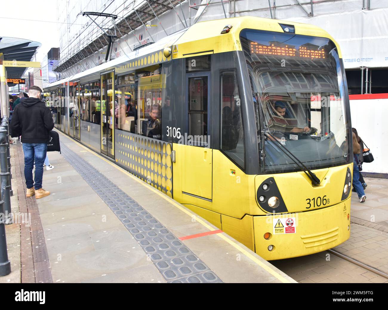 Passengers walk past a Manchester Metrolink tram at the Market Street ...