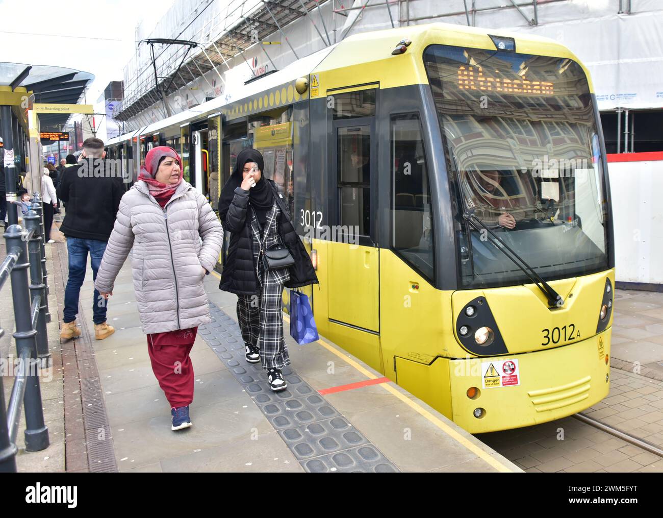 Passengers walk past a Manchester Metrolink tram at the Market Street ...