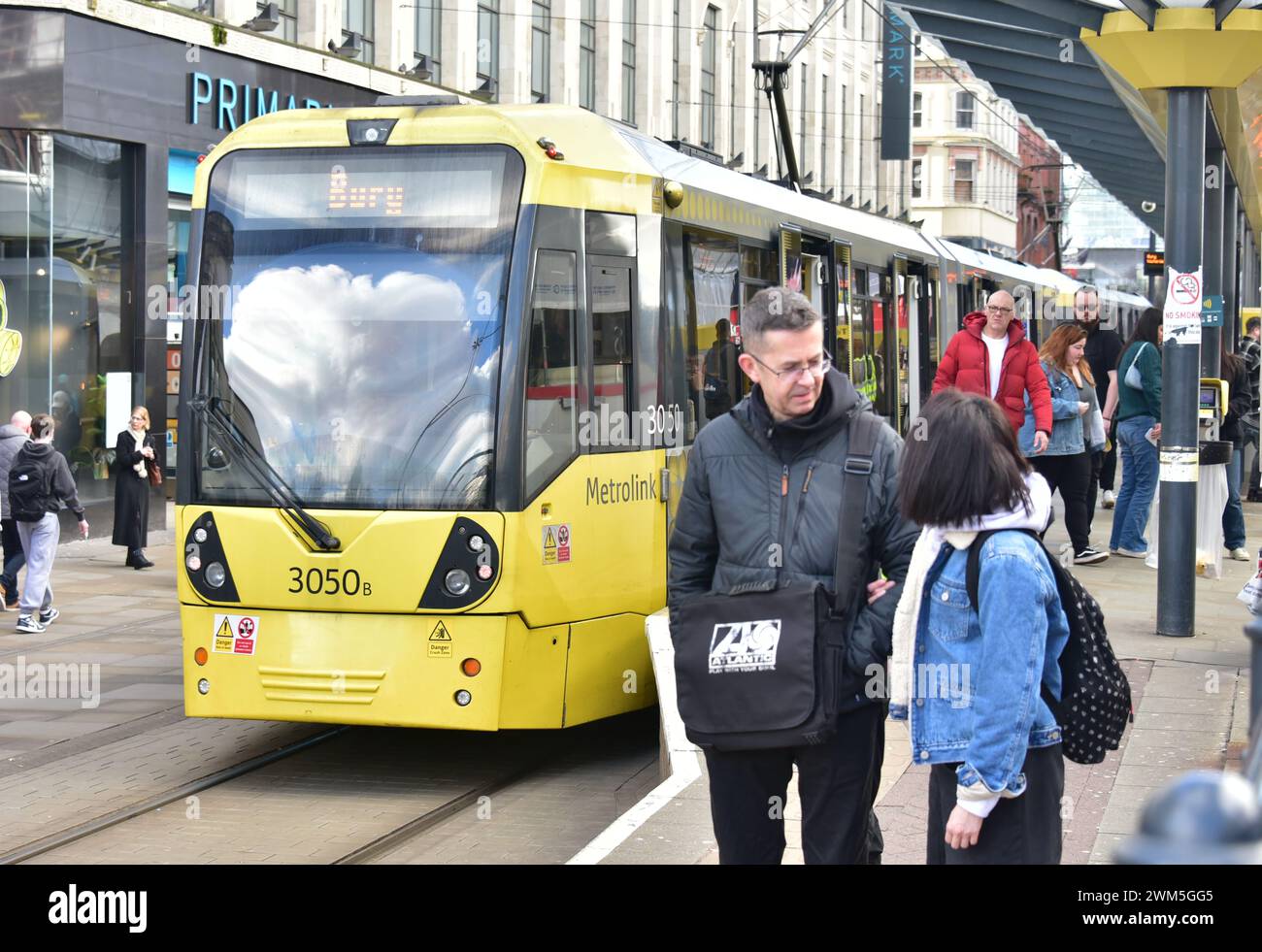 Passengers walk past a Manchester Metrolink tram at the Market Street ...