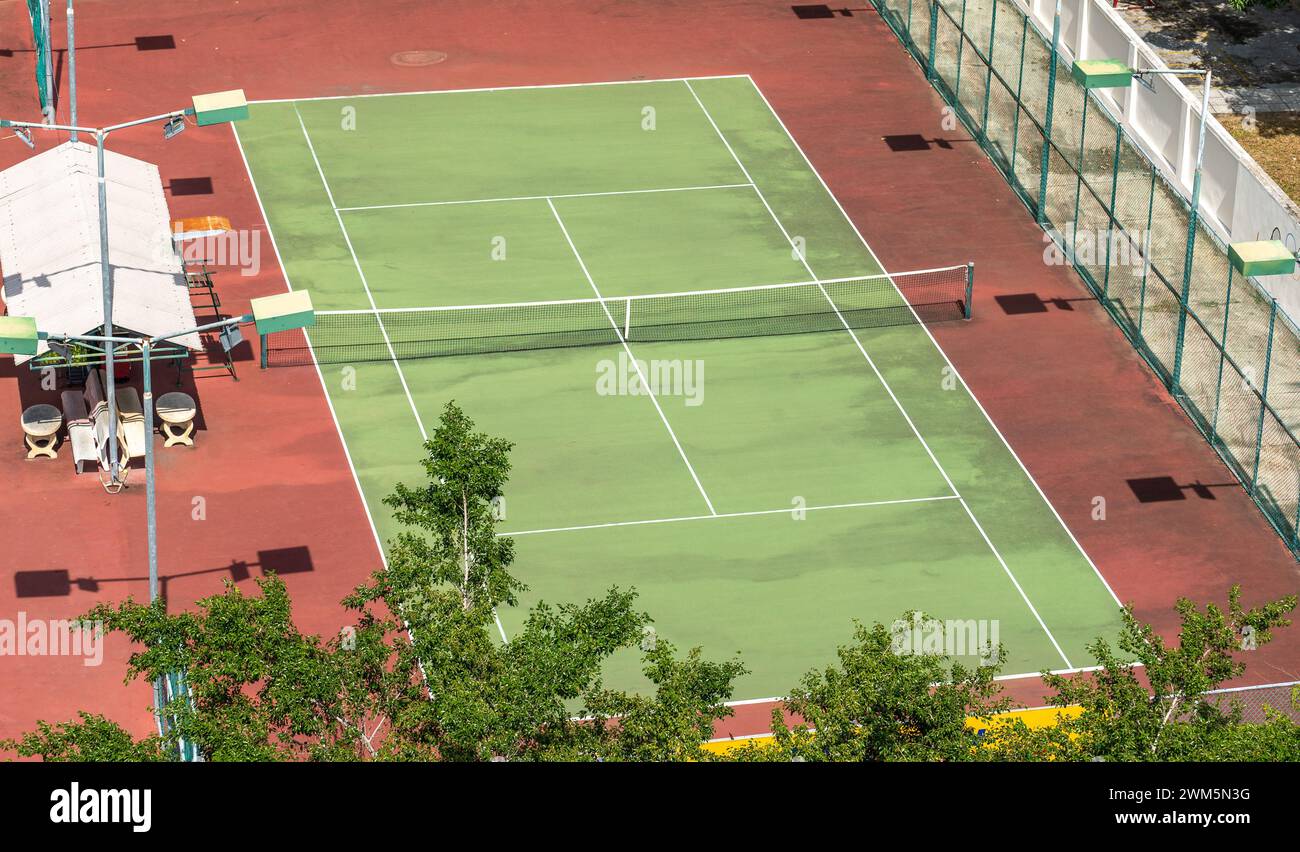 Aerial view of an outdoor tennis court under open sky, surrounded by ...