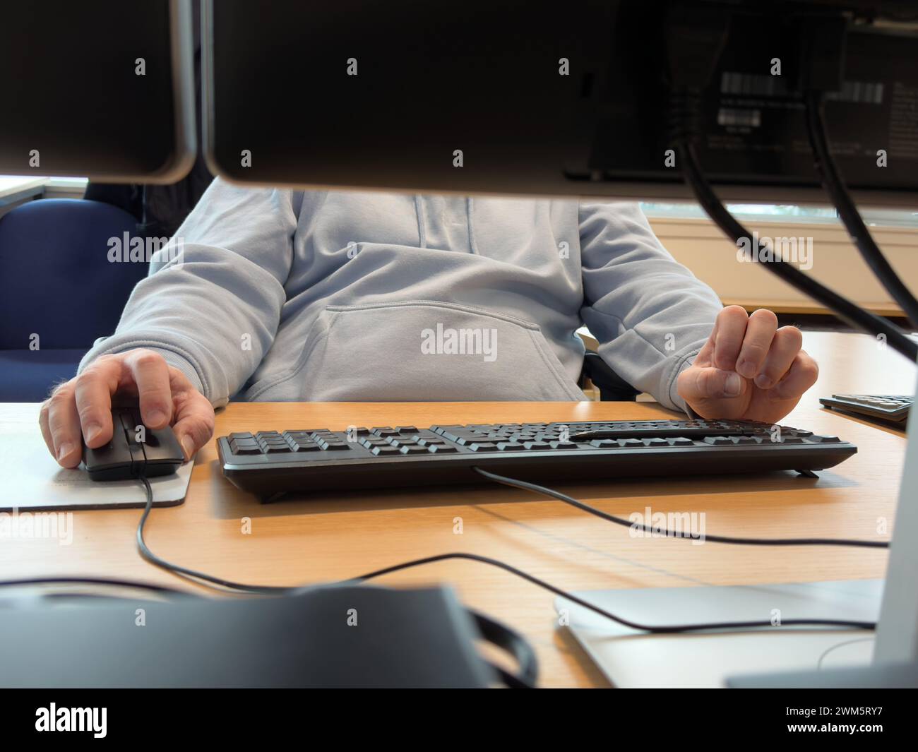 Office worker using computer at desk Stock Photo - Alamy