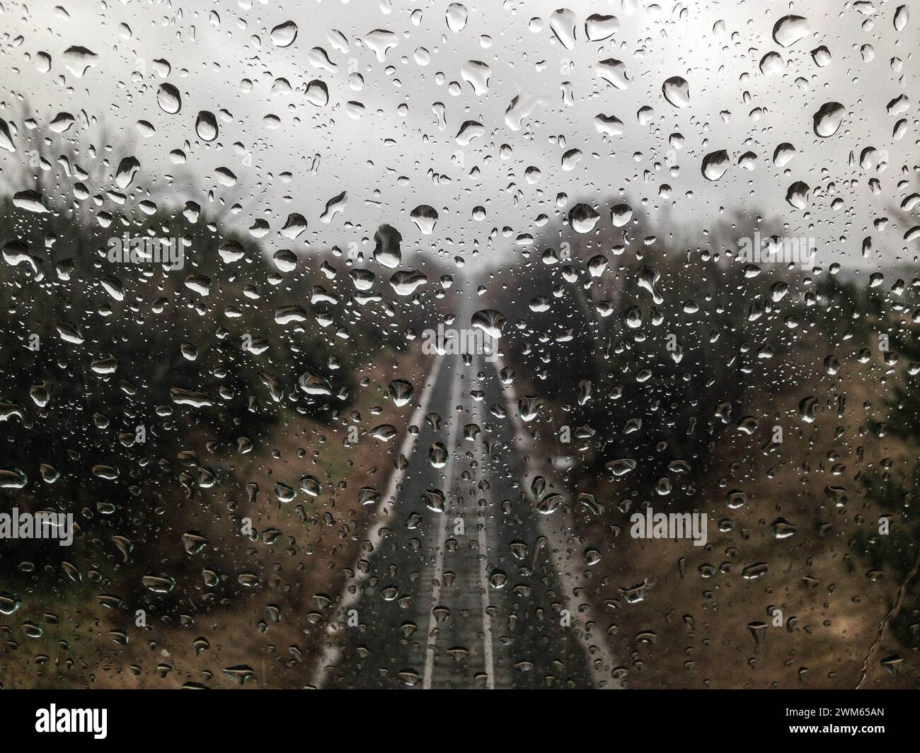 Rain covered window with railroad tracks outside Stock Photo - Alamy