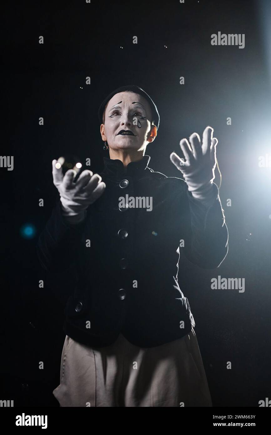 Minimal portrait of emotional mime artist playing drama on stage ...