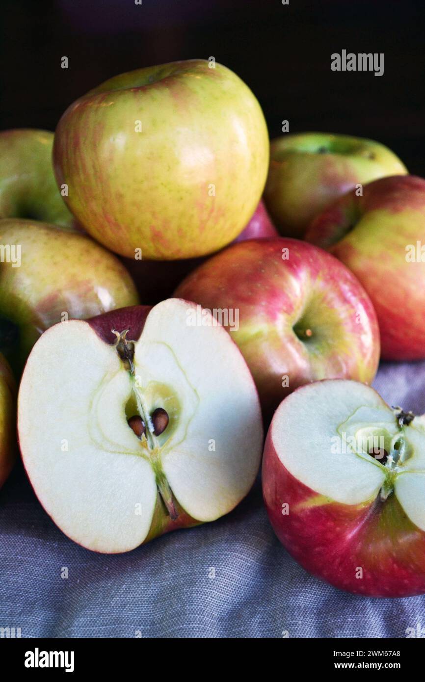 apple sliced in half with apples piled up on table Stock Photo - Alamy