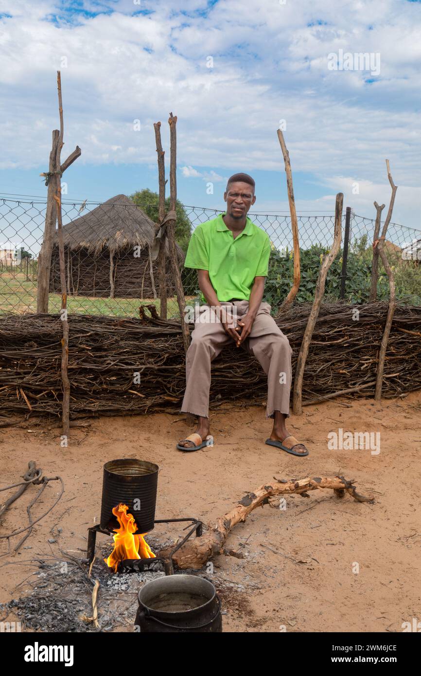 village african man standing in the yard, outdoors kitchen, in the ...