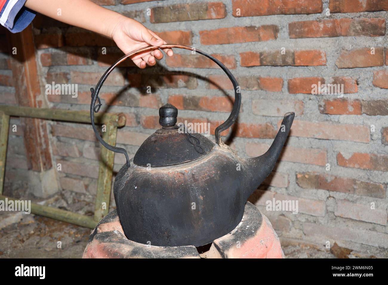 Still life typical Indonesian traditional teapot. Against a red brick ...