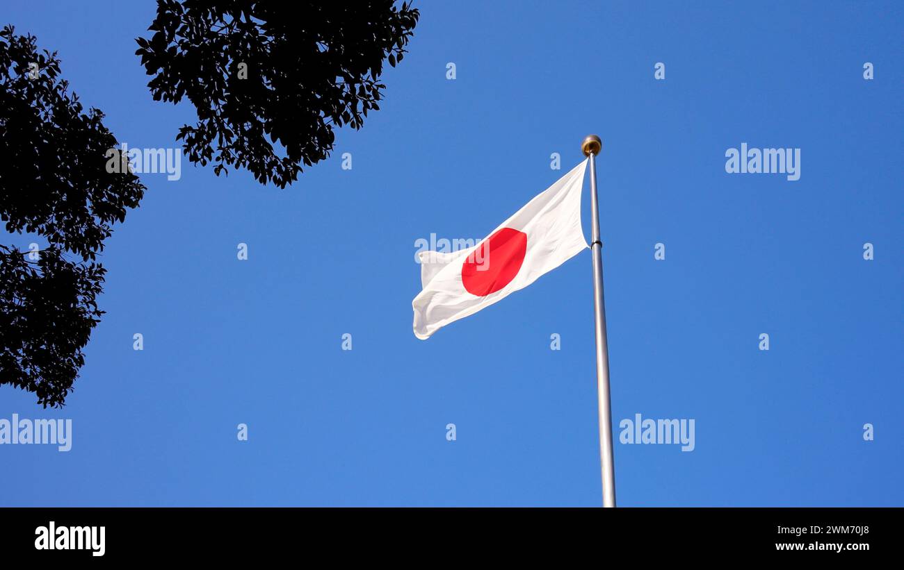 Japanese flag waving in wind with blue sky. Japan banner blowing, soft ...