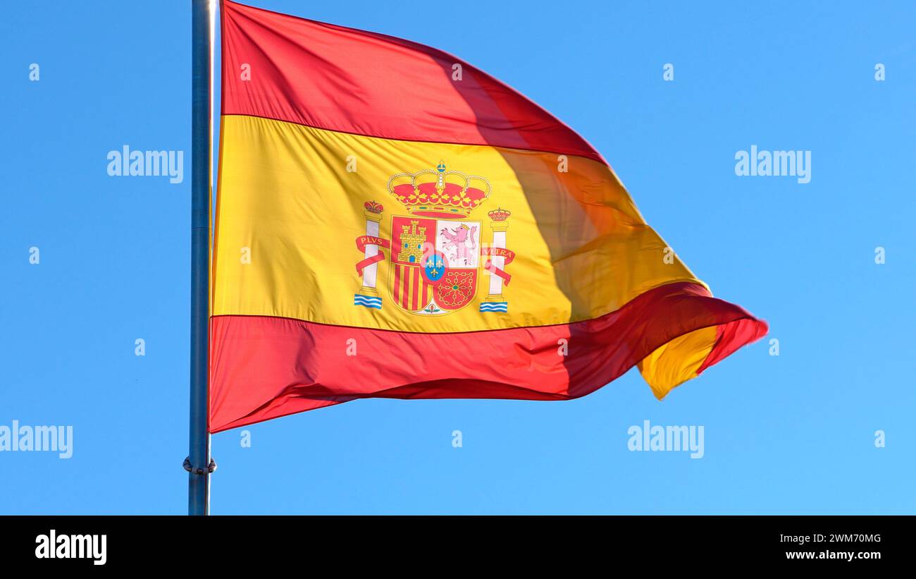 Spanish flag waving in wind with blue sky. Spain banner blowing, soft ...