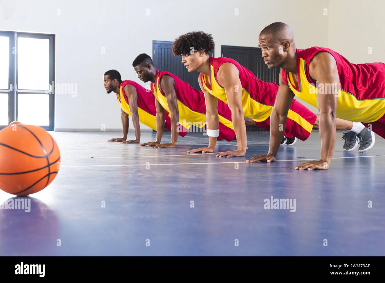 Diverse basketball players do push-ups in a gym, with copy space Stock Photo - Alamy