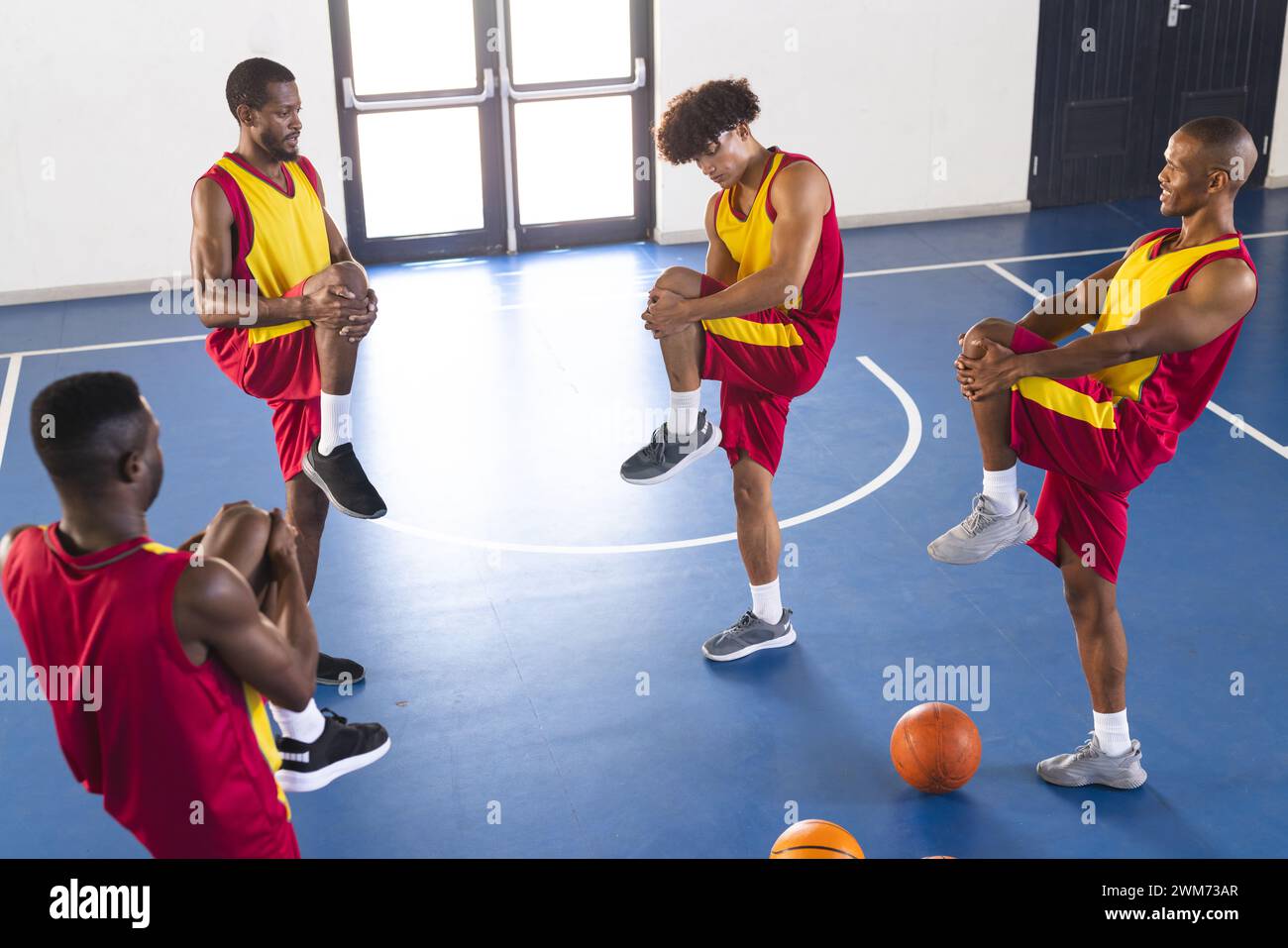 Diverse basketball players stretch before a game Stock Photo - Alamy