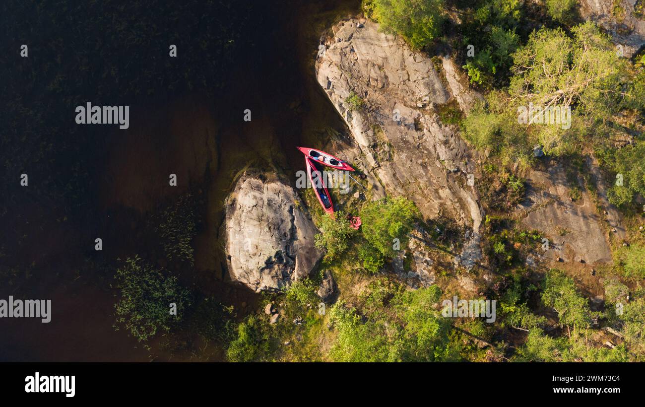 Aerial view reveals a vibrant red kayak resting on the sun-kissed ...