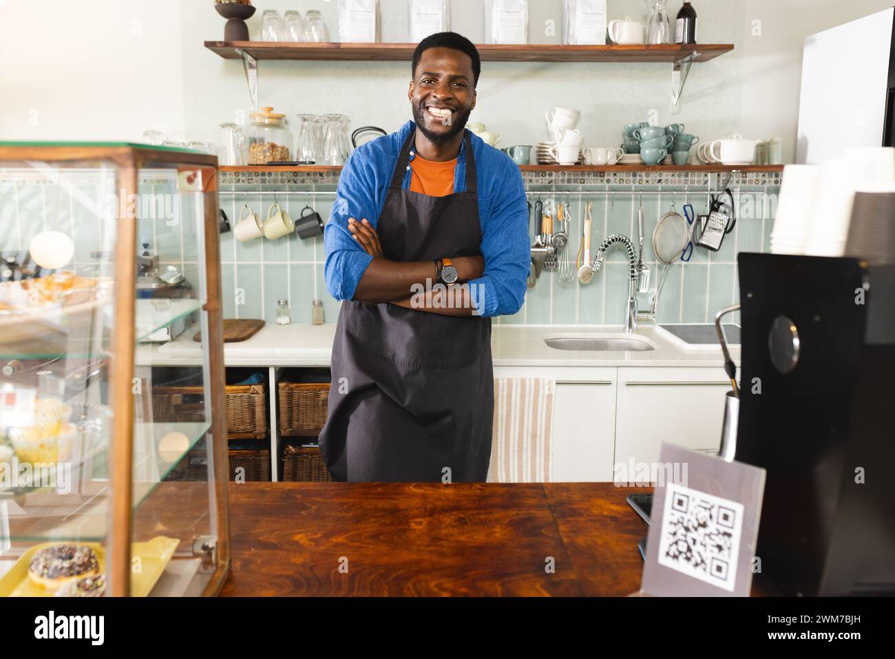 A cheerful African American man stands behind a cafe counter Stock ...