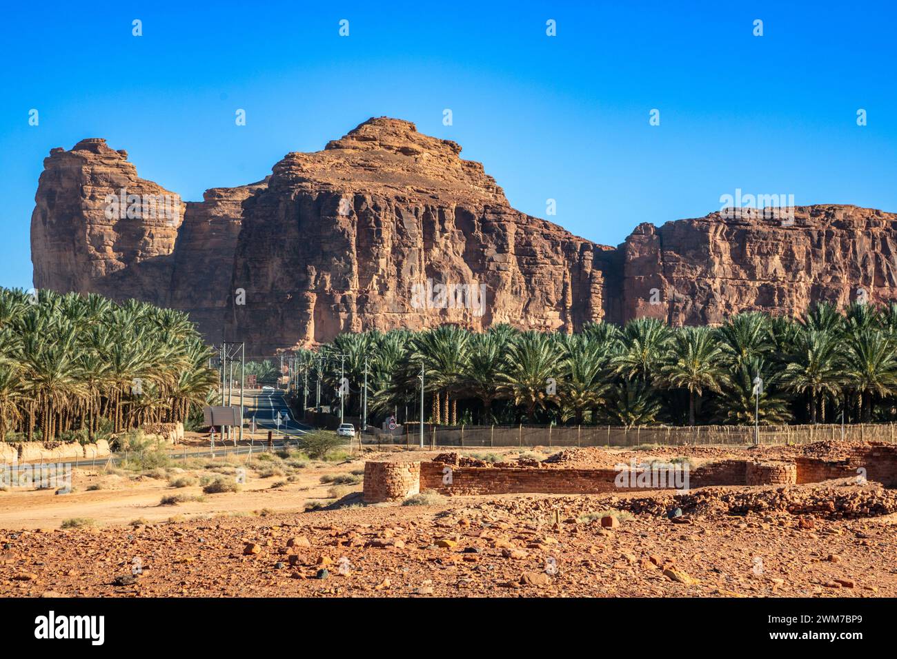 Desert mountains with ruins of Dadan and road with palms, Al Ula ...