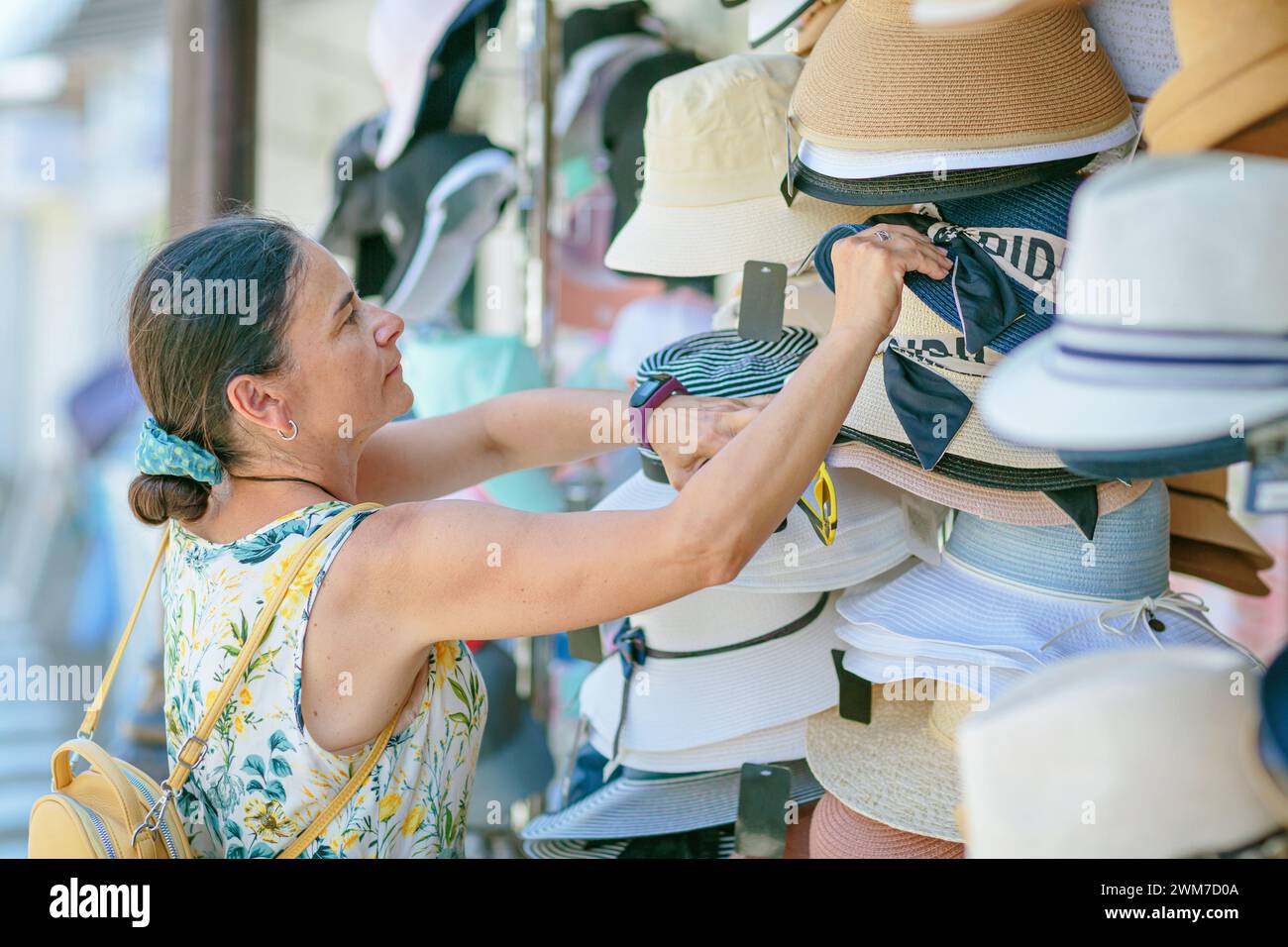 Woman choosing summer hat hi-res stock photography and images - Alamy