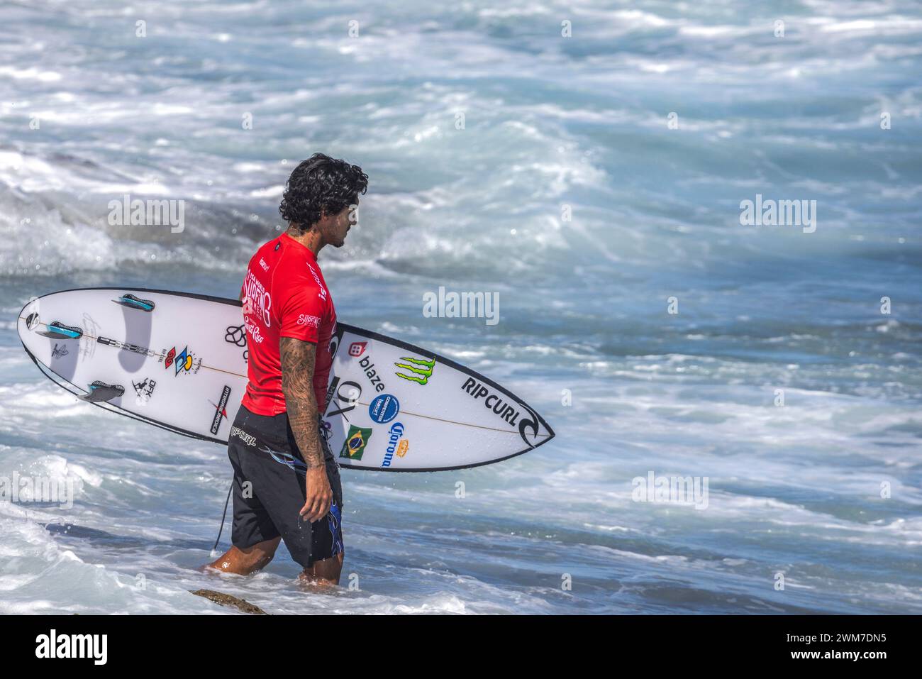 Gabriel Medina from Brazil, wades into the water to begin his ...
