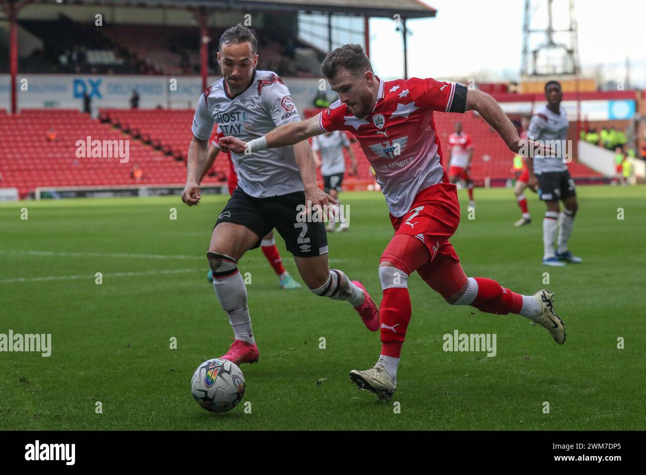 Nicky Cadden of Barnsley breaks with the ball pressured by Kane Wilson ...