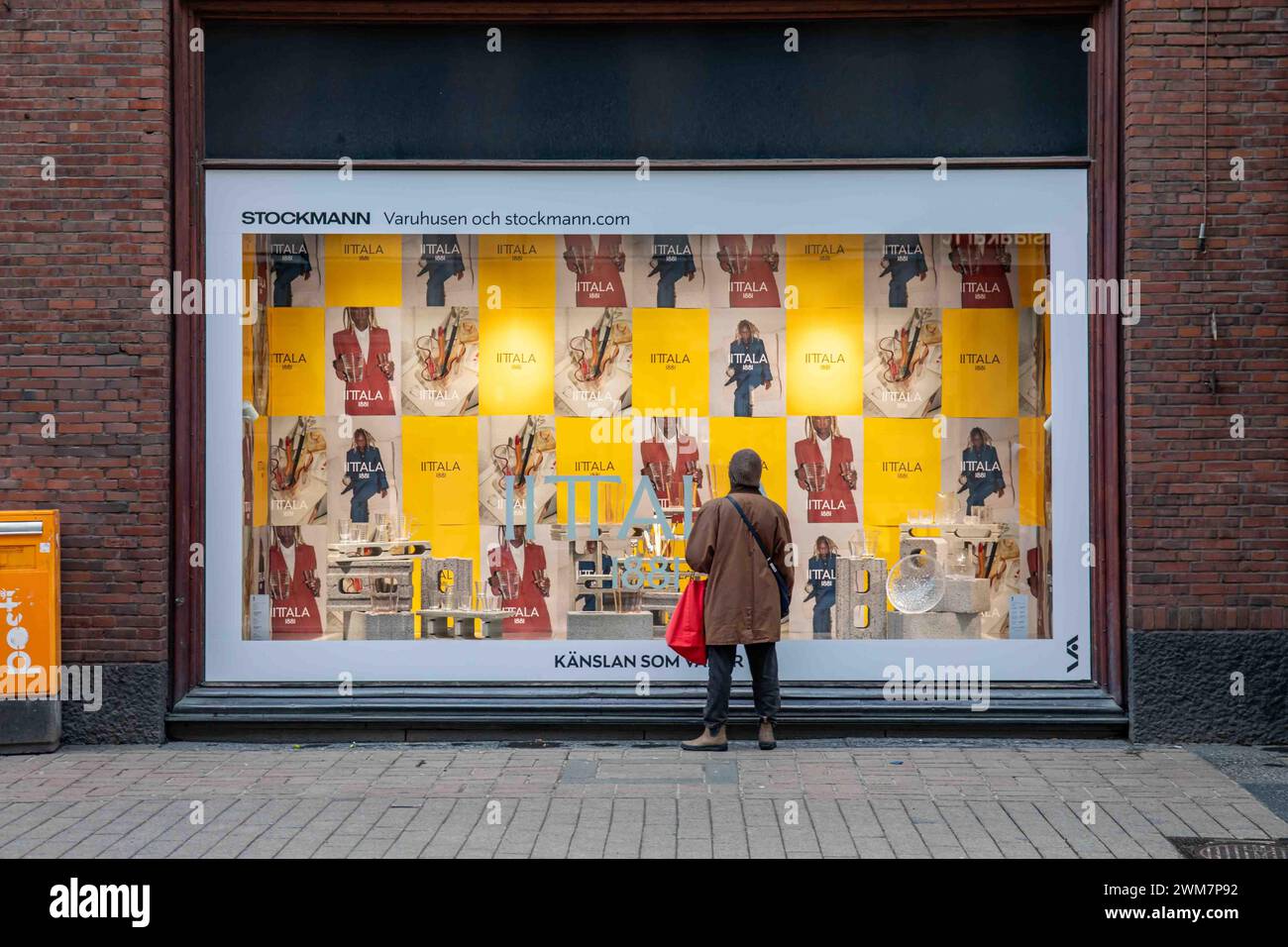 Woman looking at Iittala's new brand and logo displayed on Stockmann ...