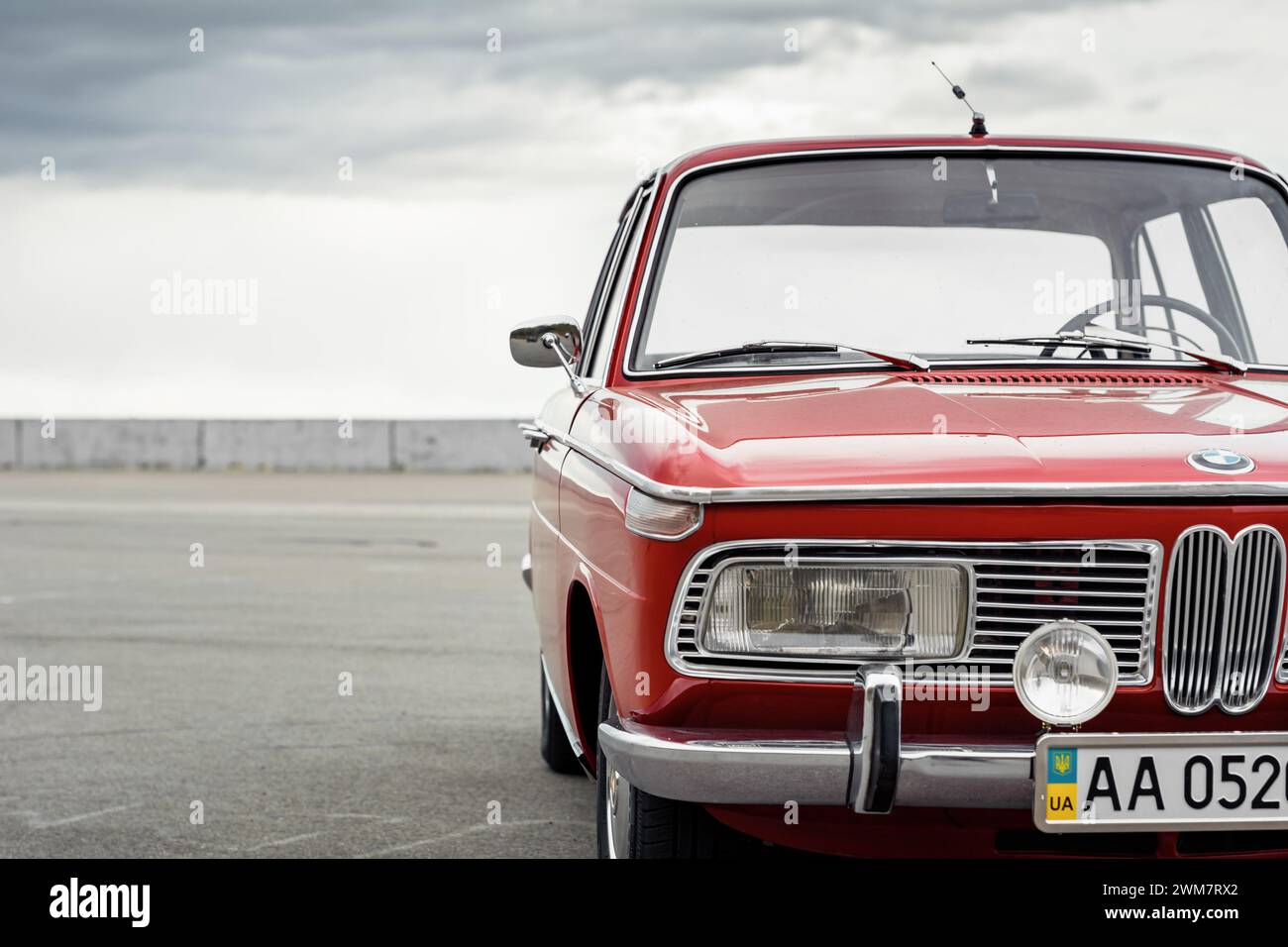 Red classic BMW from 1960s. Front corner of german sedan parked on big ...