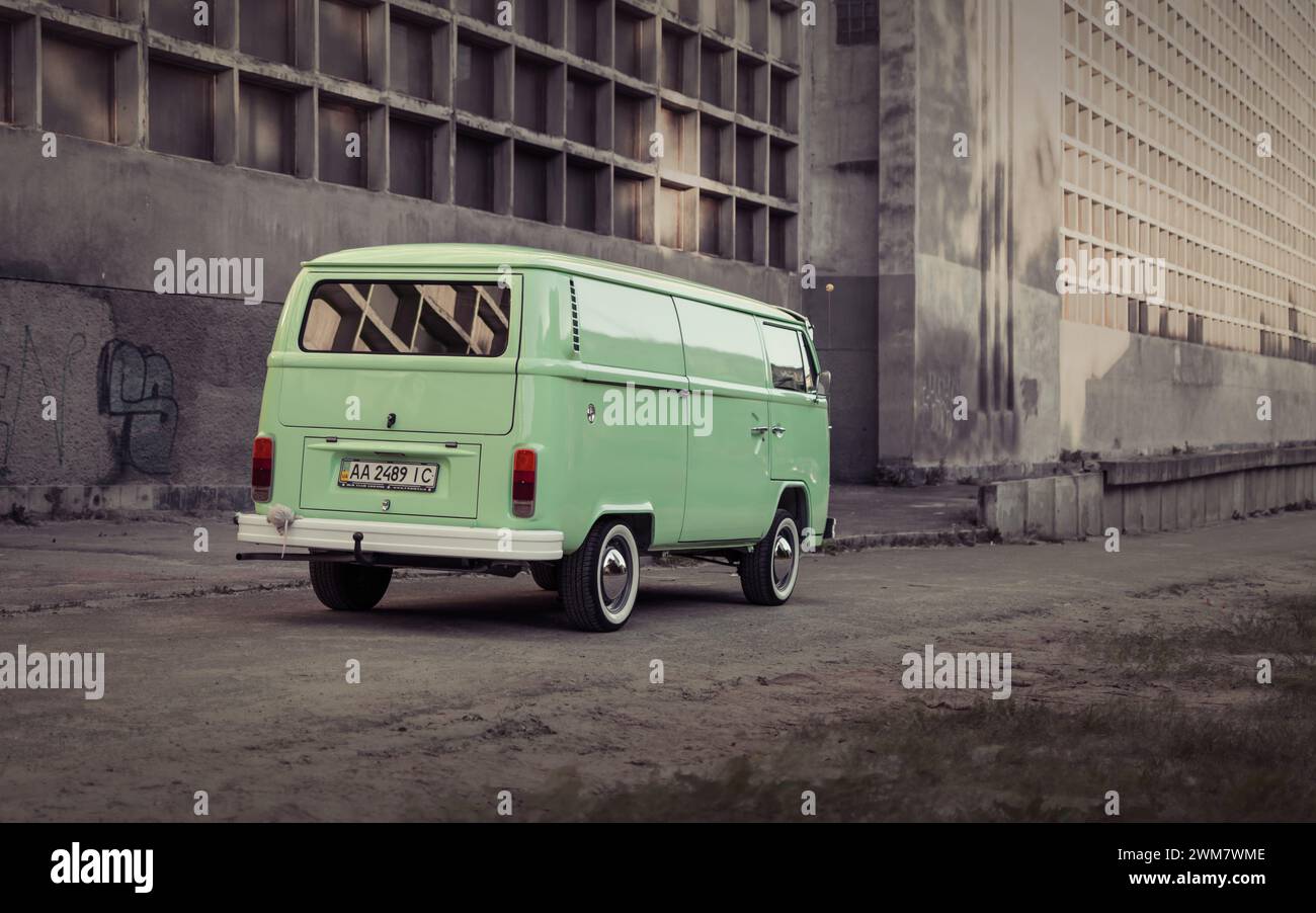 Green classic Volkswagen Transporter bus parked in front of concrete ...