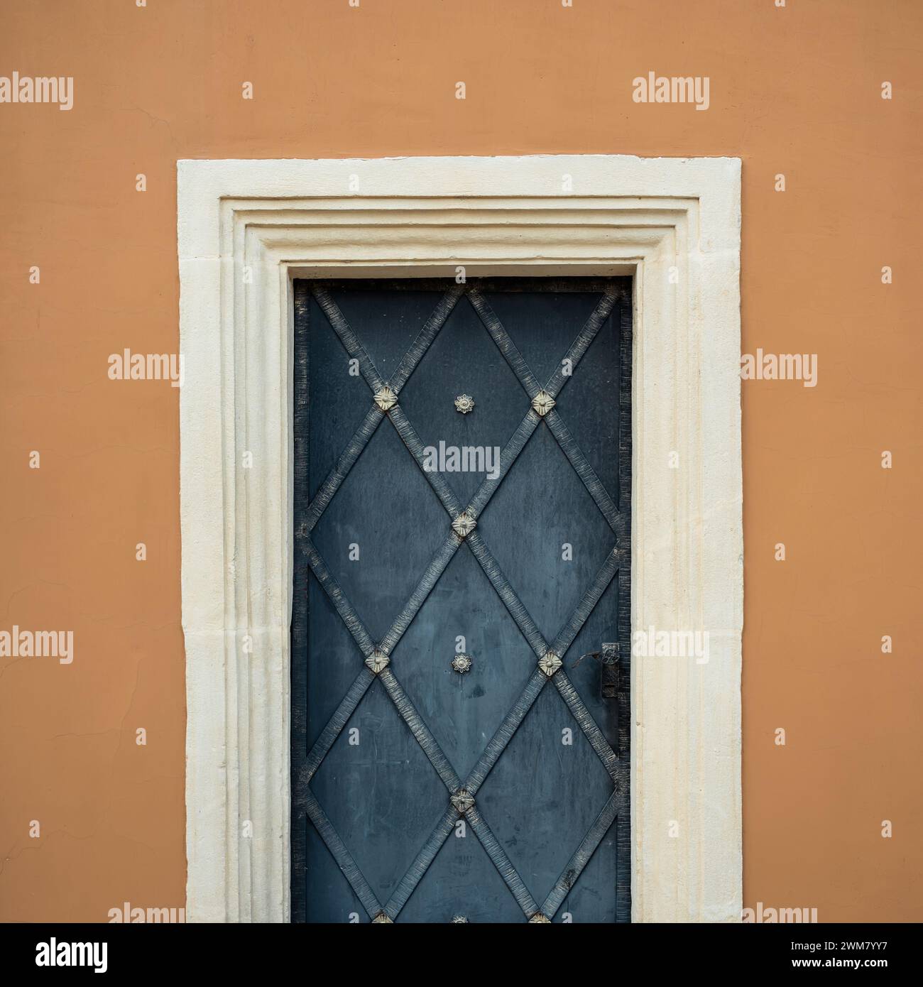 Exterior of old brown house with indigo blue painted iron door. Blue ...