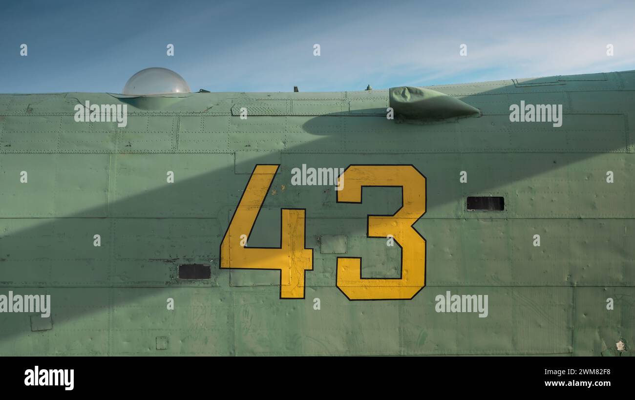Number 43 written on side of old military aircraft. Green metal surface ...