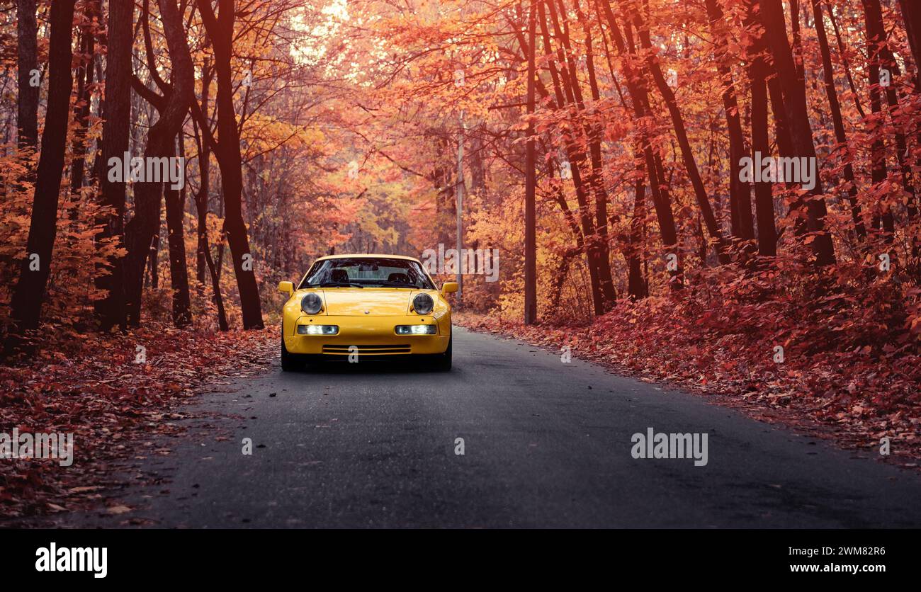 yellow Porsche 928 in autumn forest. Facing up 1980s german sportscar ...
