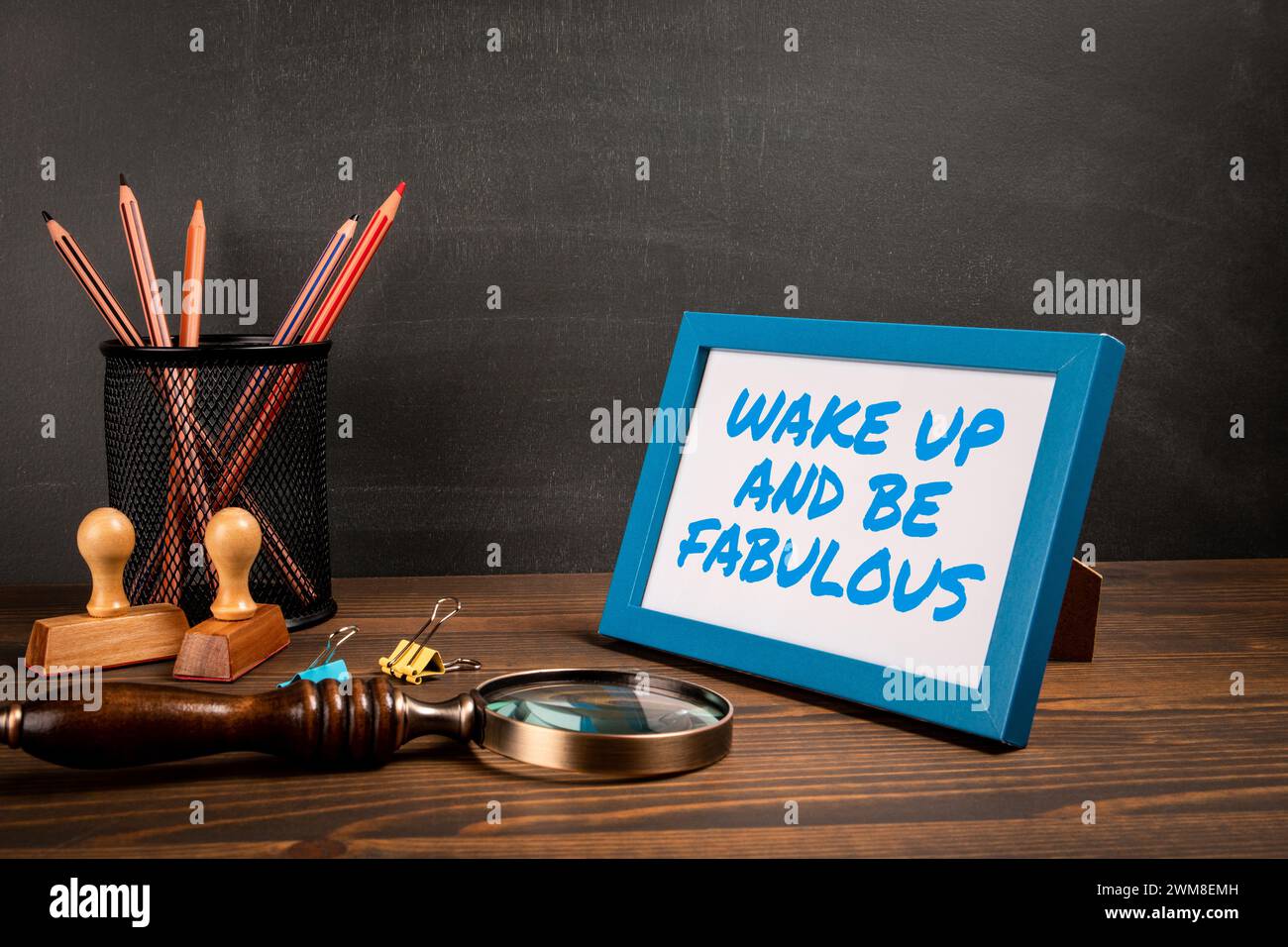 WAKE UP AND BE FABULOUS. A picture frame on a wooden office table Stock ...