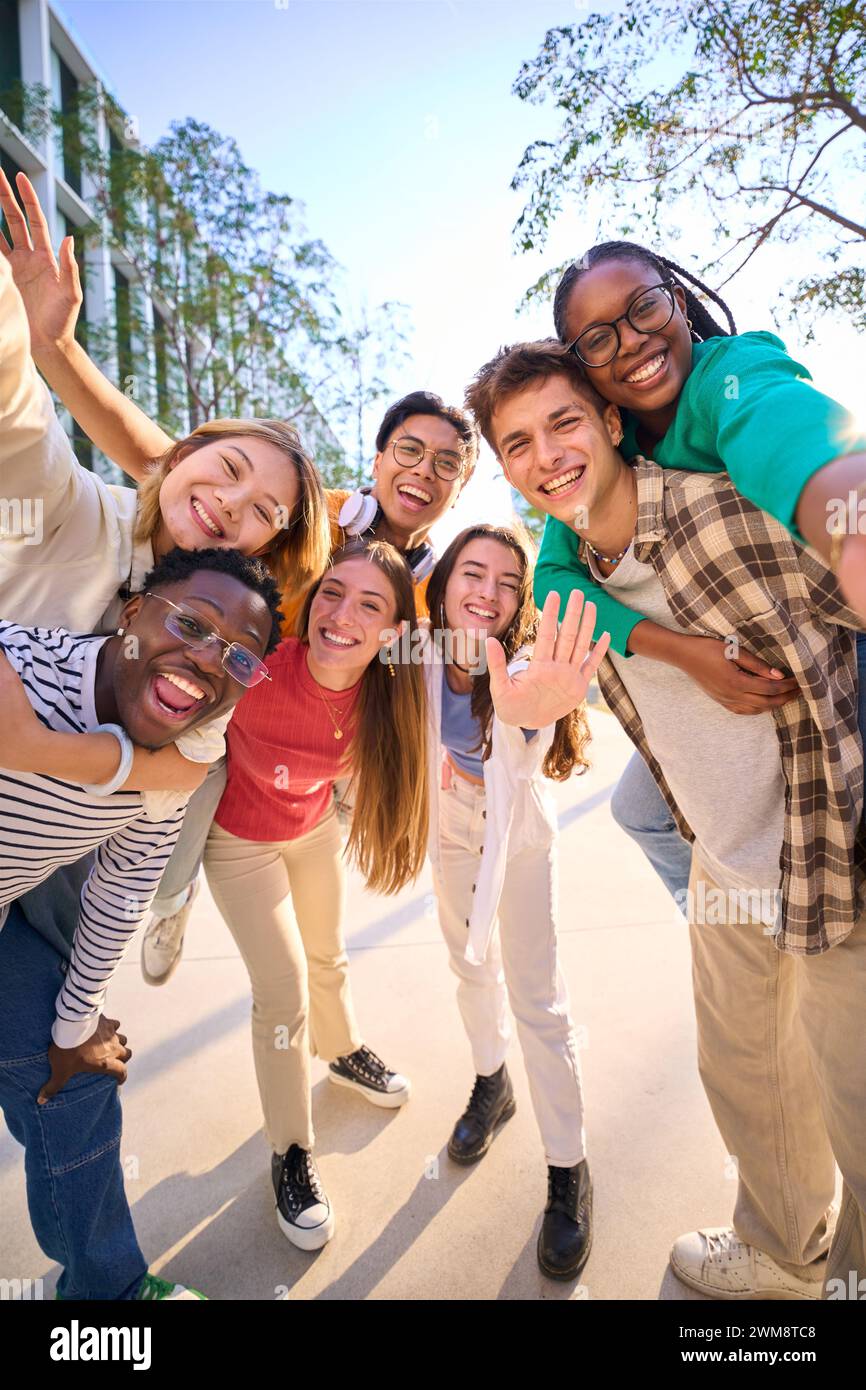 A large multiracial group of teenagers taking a selfie looking front ...