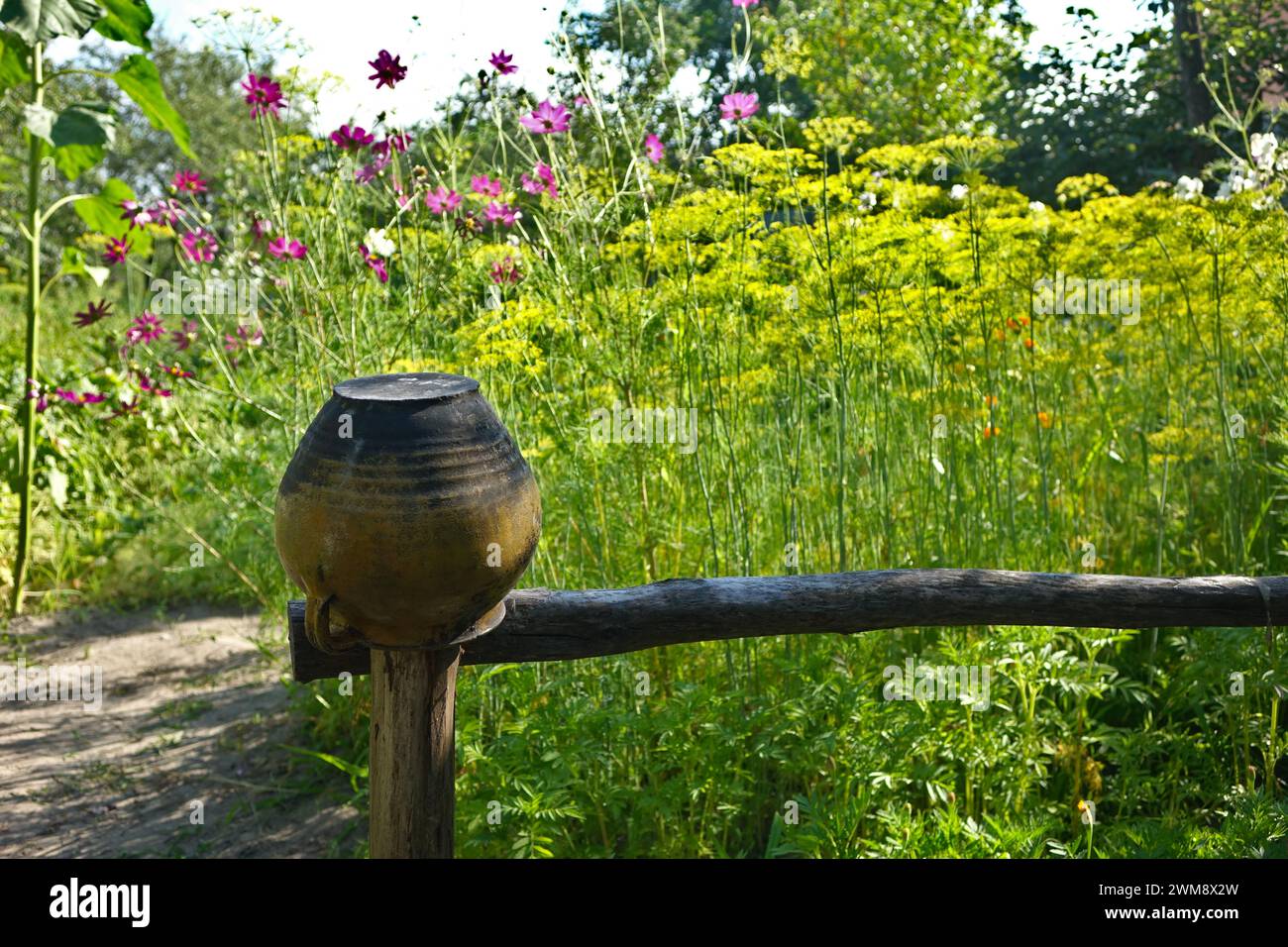 Ceramic pot for food on a pillar of an old wooden fence of a vegetable ...