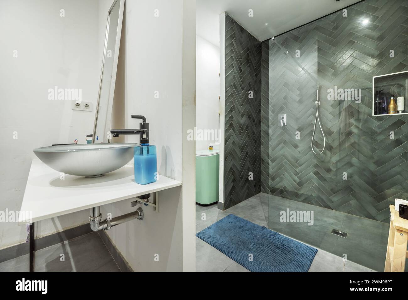 White countertop in a bathroom with silver semicircular sink, black ...