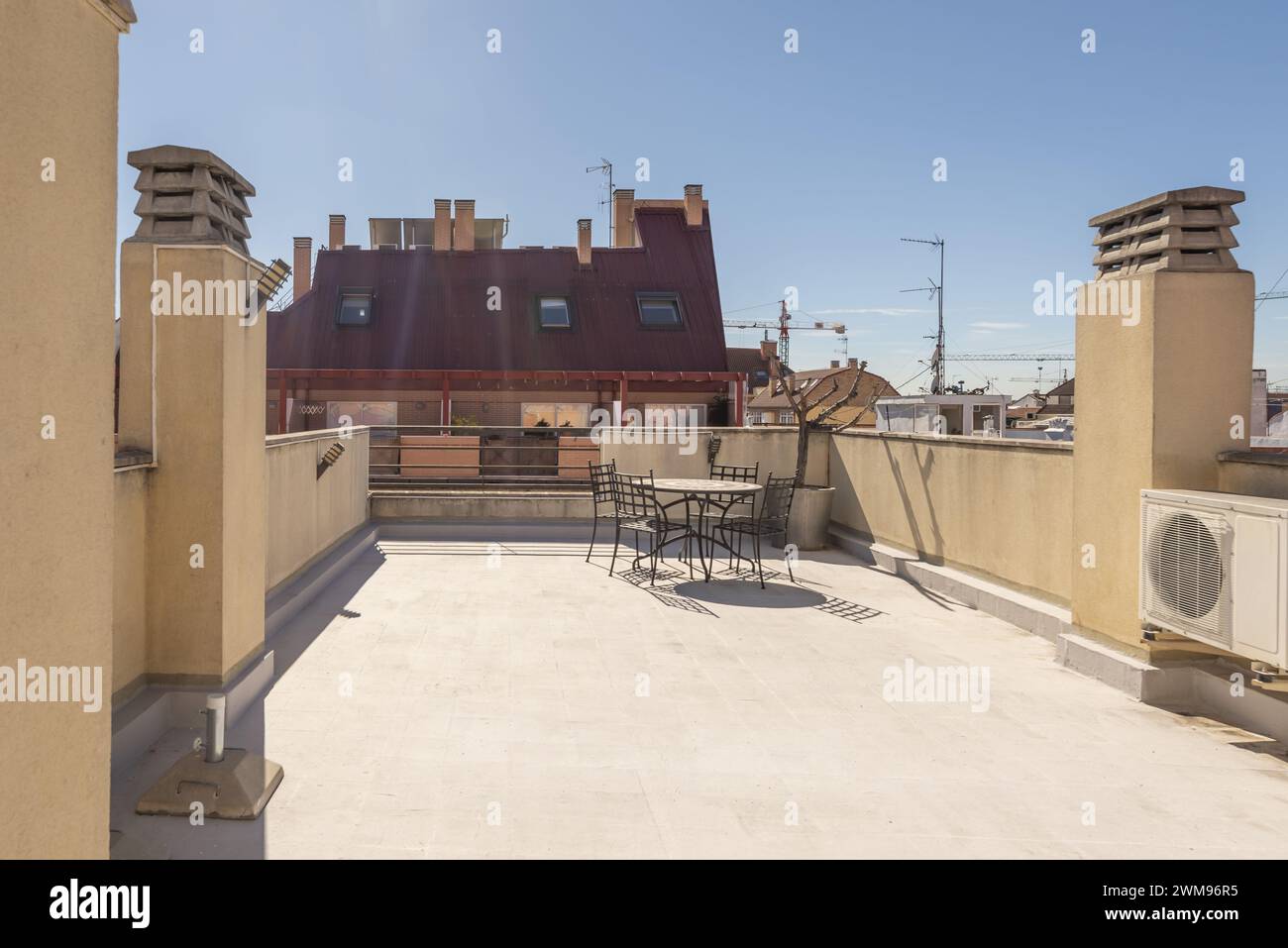 Roof of a building with a circular metal garden table and matching ...