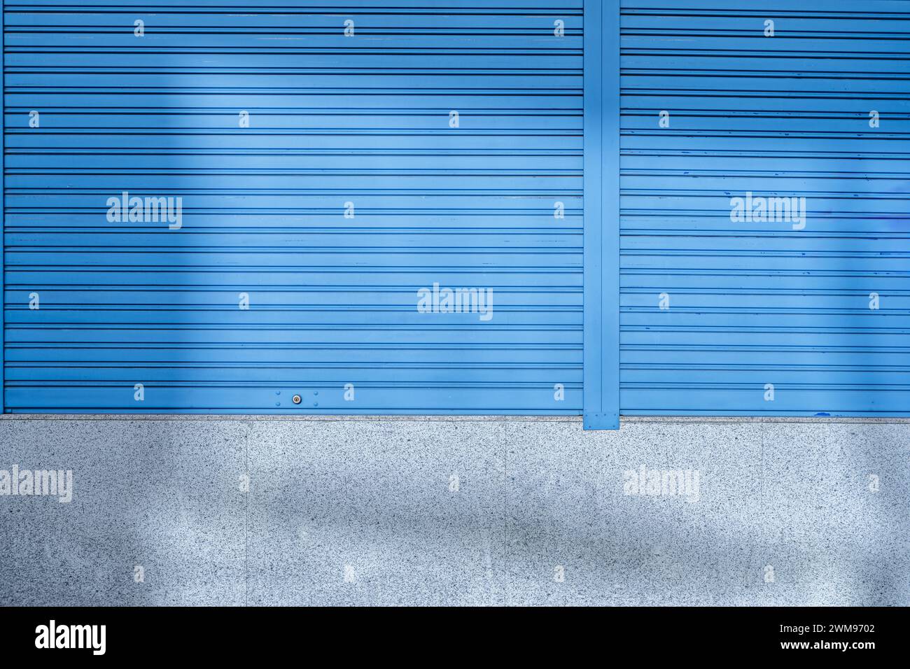 Blue metal shutters with security closure on the granite facade in a ...