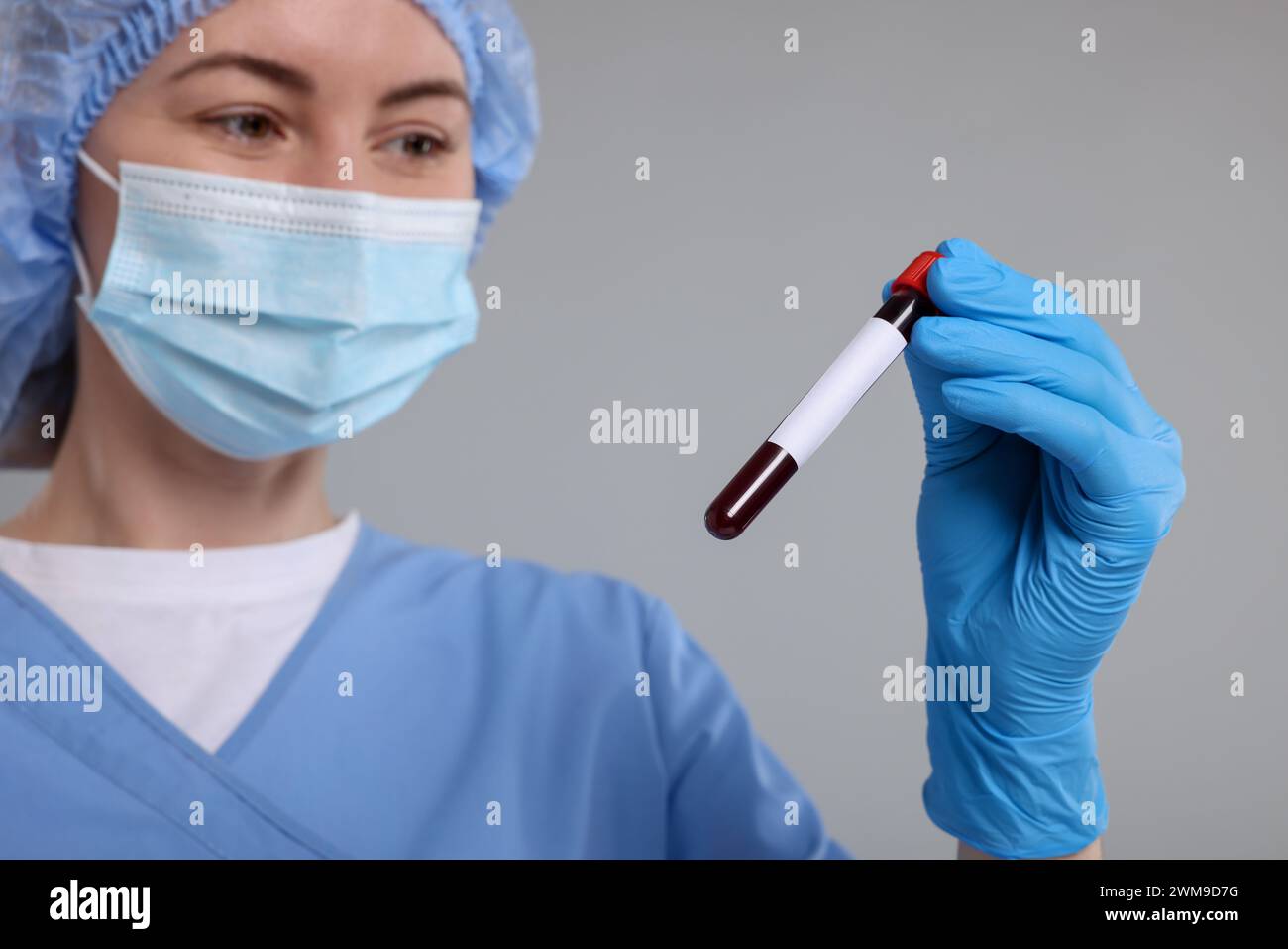 Laboratory testing. Doctor with blood sample in tube on light grey ...