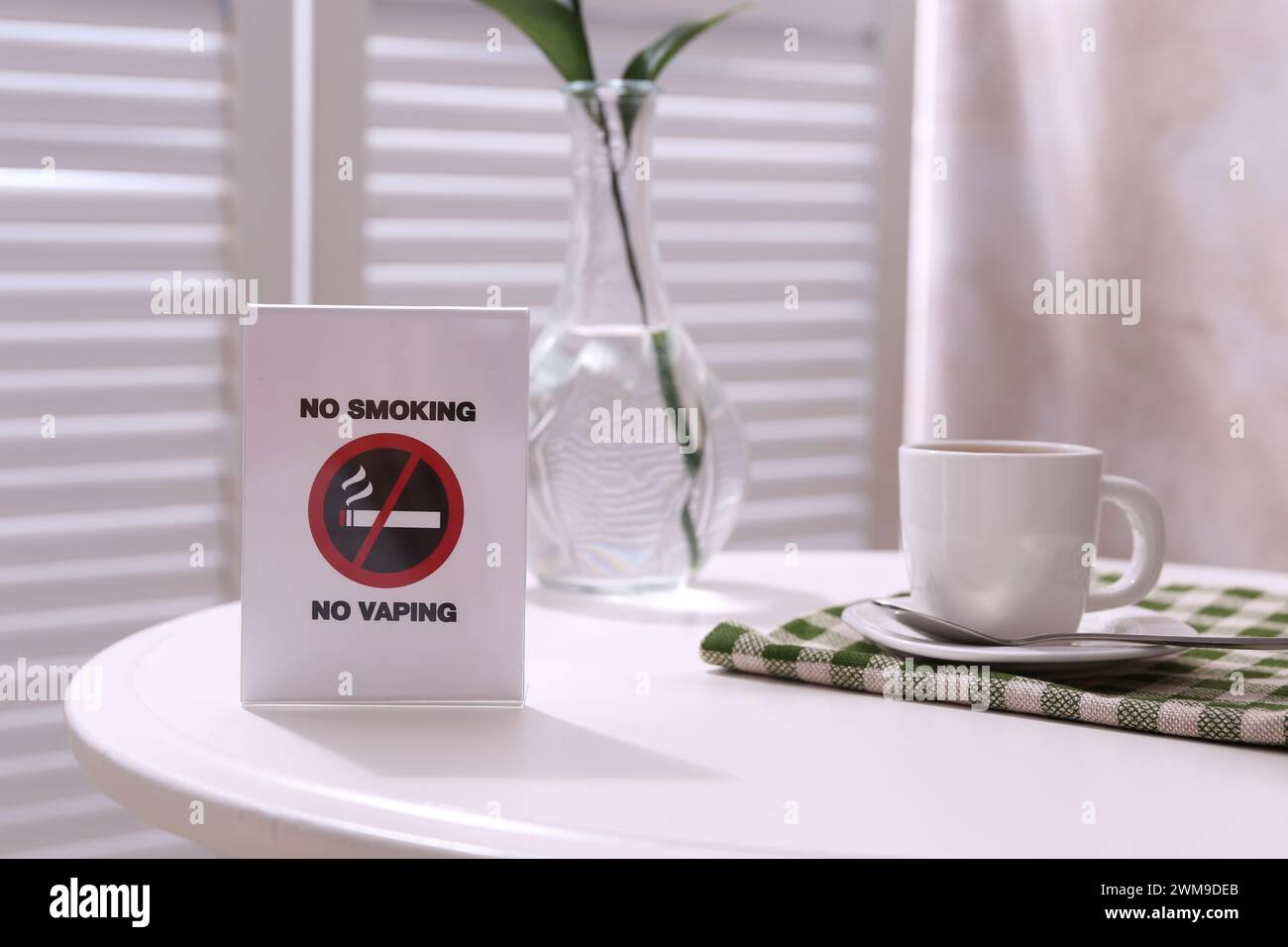 No Smoking No Vaping sign and cup of coffee on white table indoors ...