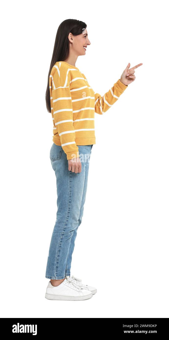 Happy woman pointing at something on white background Stock Photo - Alamy