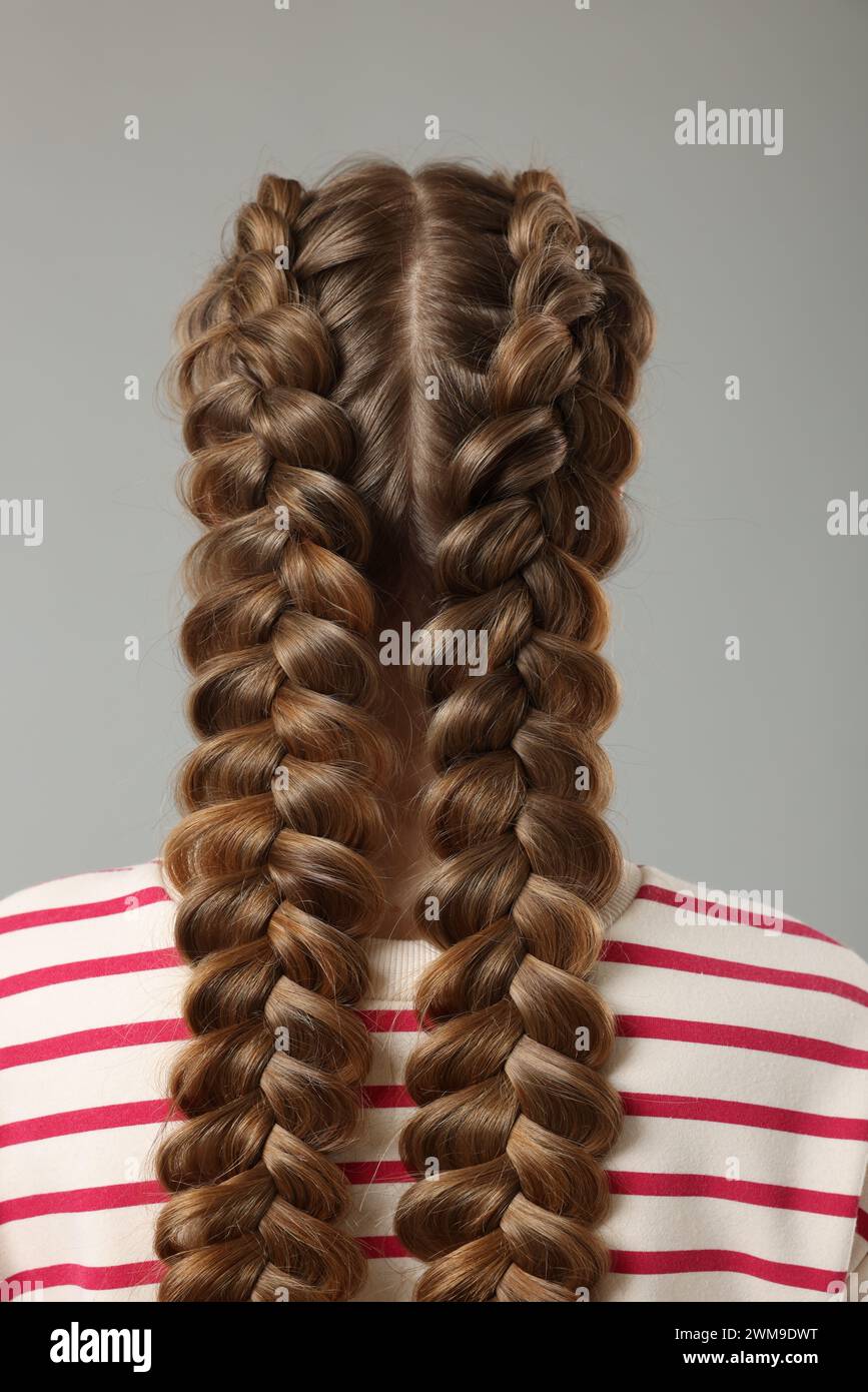Woman with braided hair on grey background, back view Stock Photo - Alamy