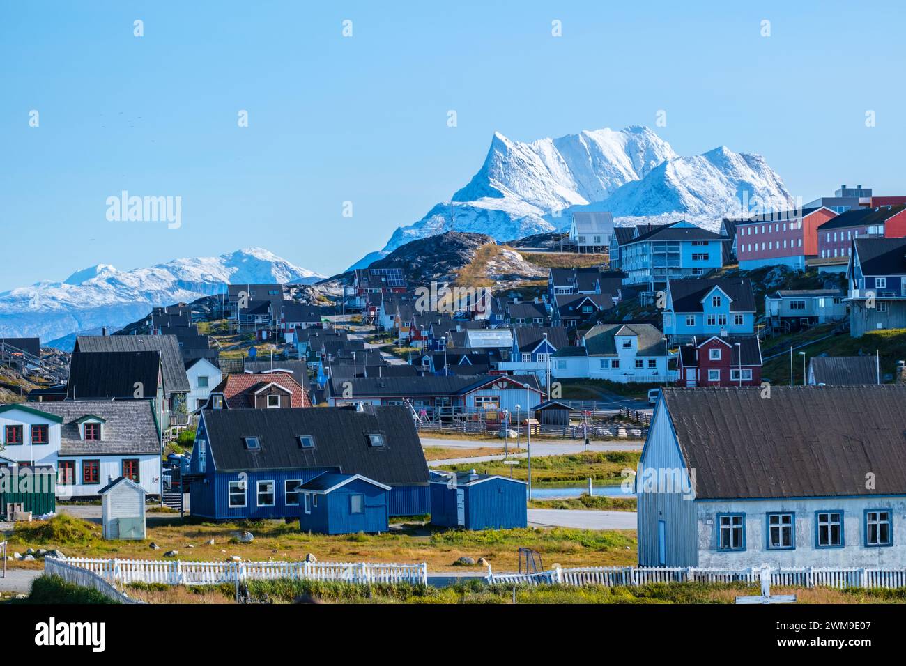 Fresh snow cover the peak of Sermitsiaq with the colourful housing of ...
