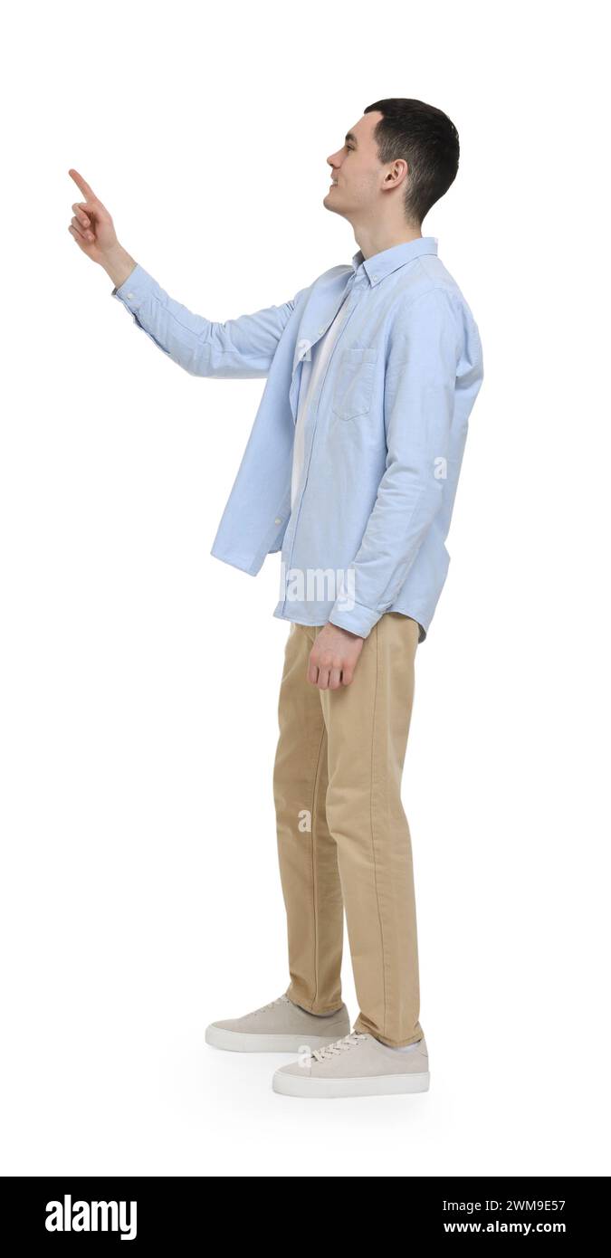 Young man pointing at something on white background Stock Photo - Alamy