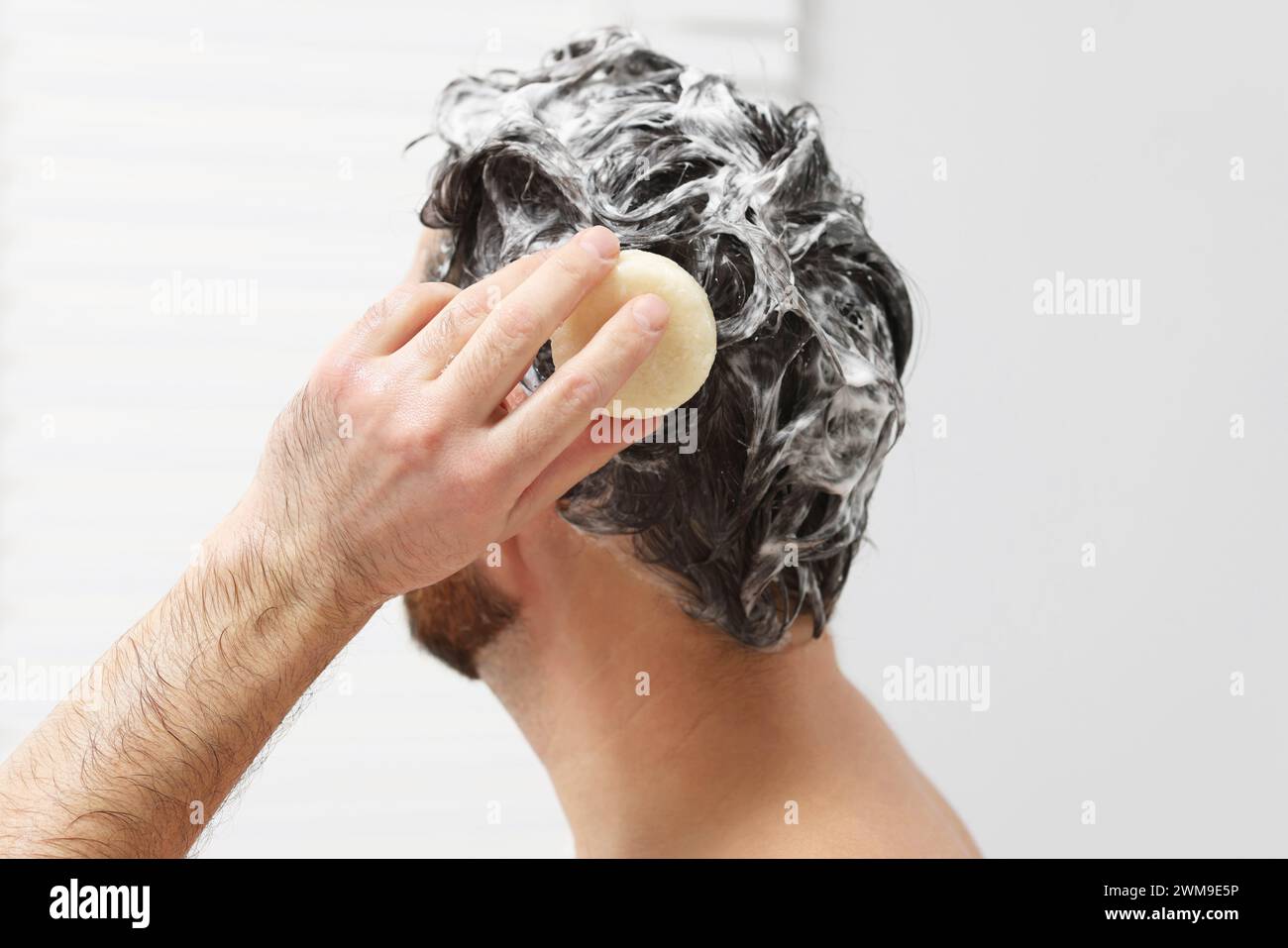 Man washing his hair with solid shampoo bar in shower, closeup Stock ...