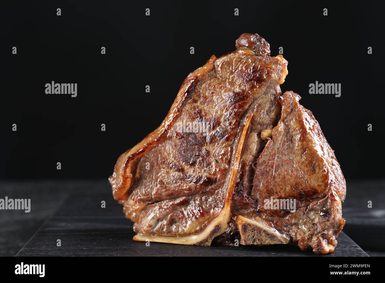 Delicious fried beef meat on table against black background Stock Photo ...