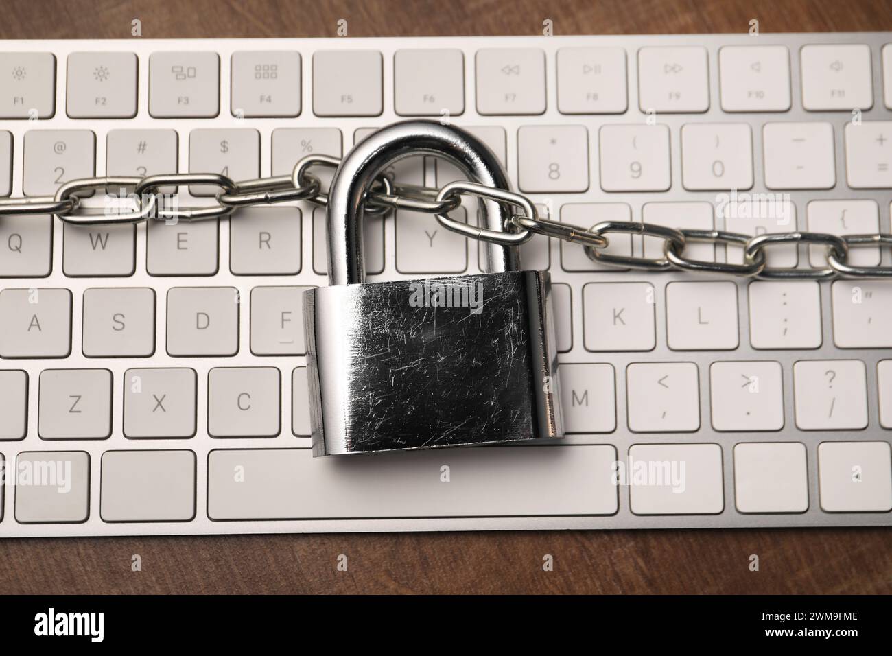 Cyber security. Keyboard with padlock and chain on wooden table, top view Stock Photo - Alamy