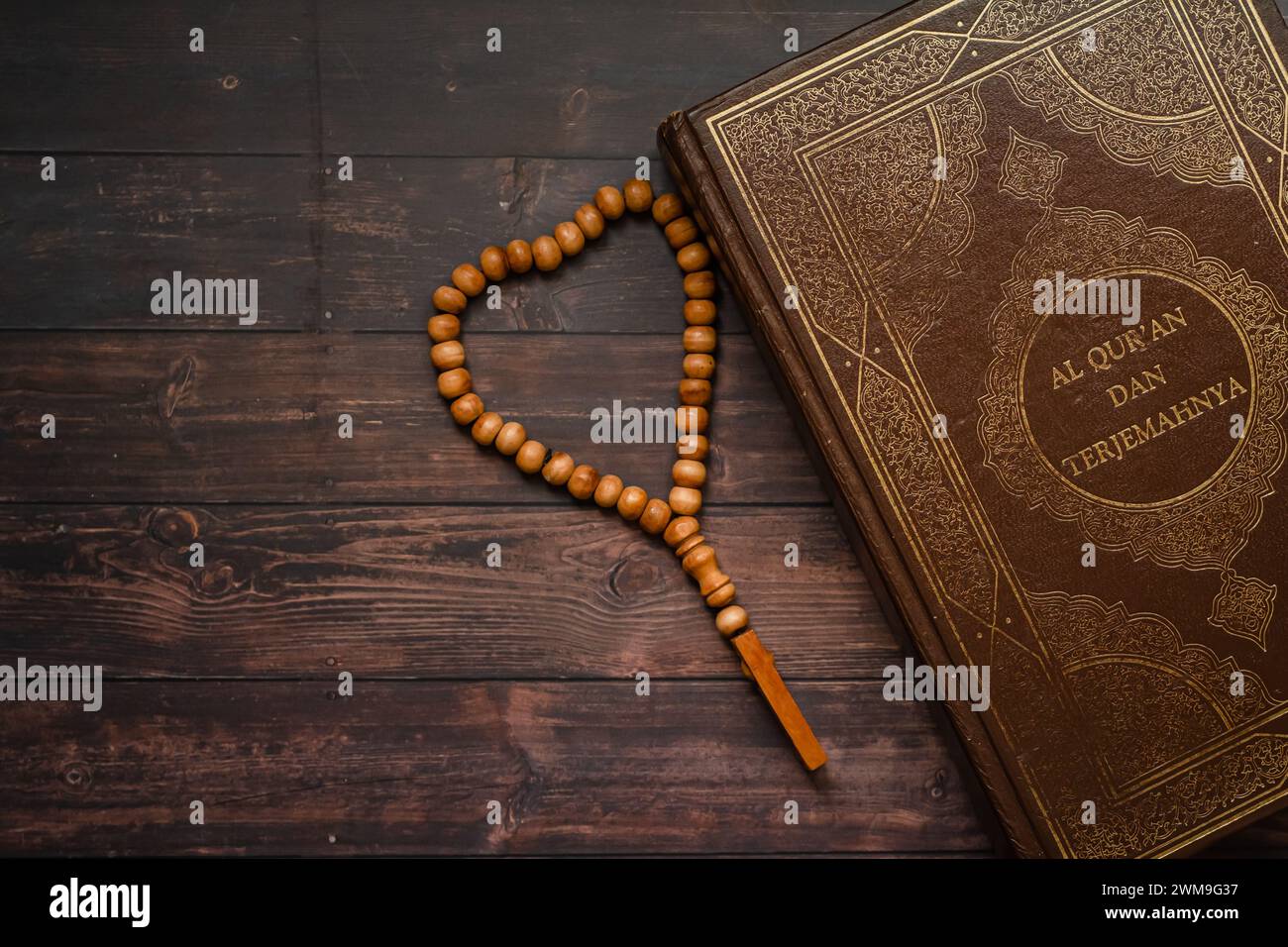 Islamic holy book Quran on wooden table background with tasbih ...