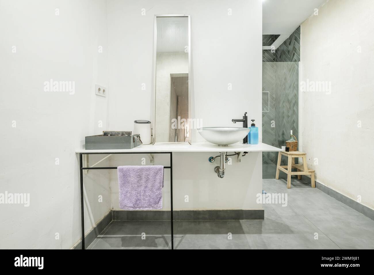 White countertop in a small bathroom with silver semicircular sink ...