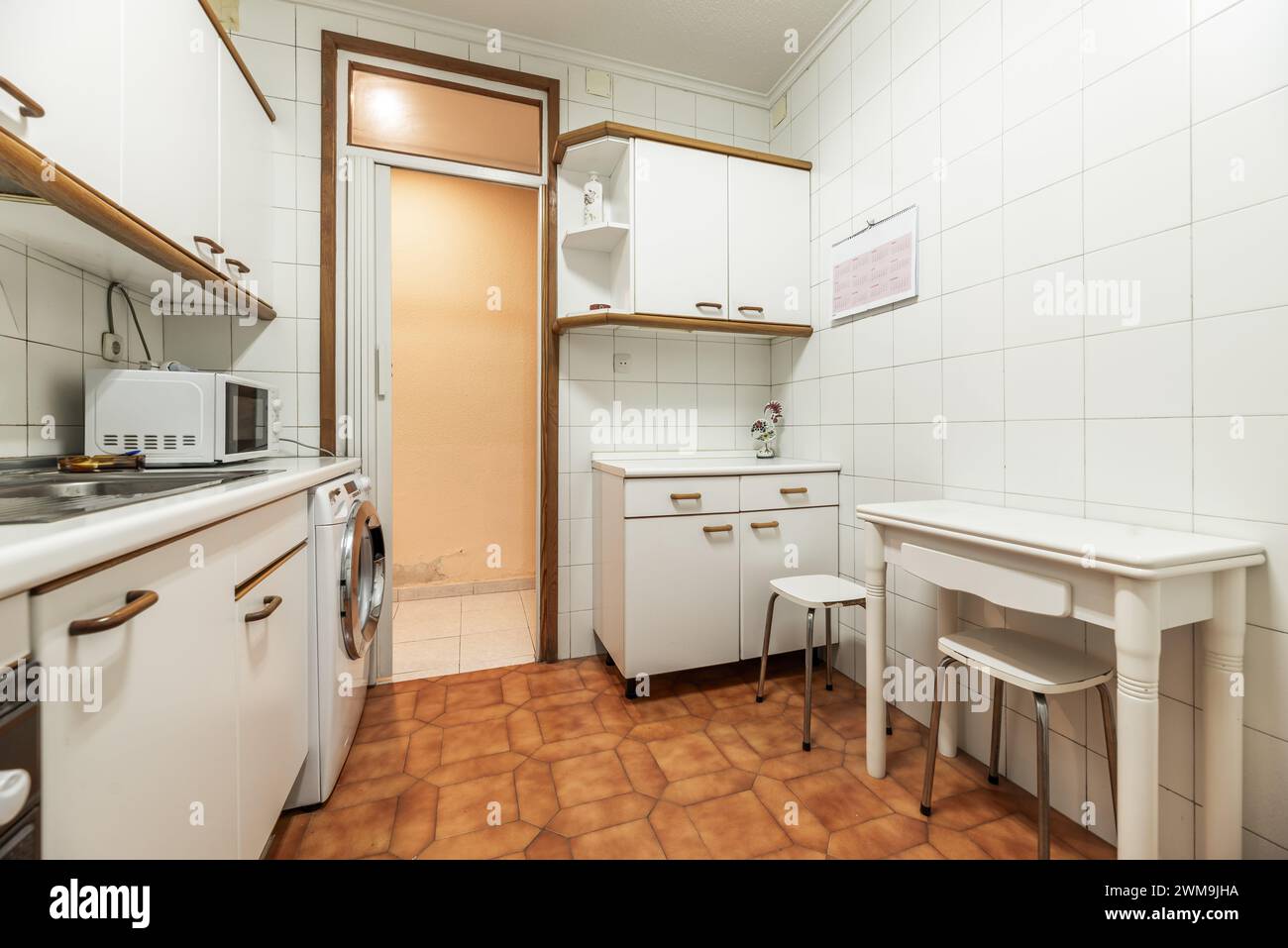Kitchen furnished with old white furniture with wooden handles ...