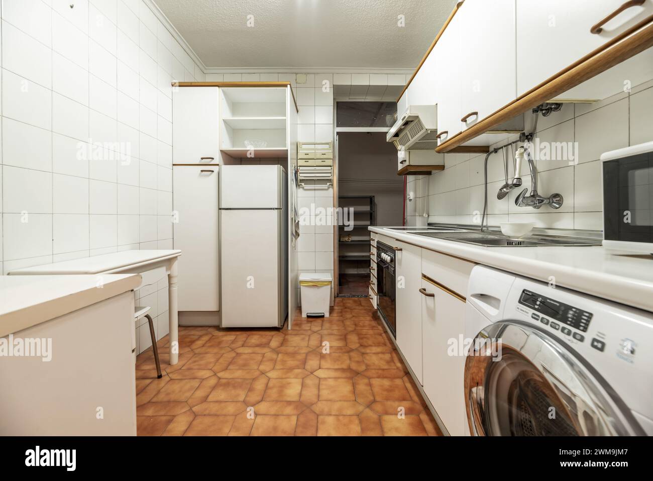 Kitchen furnished with antique white furniture with wooden handles ...