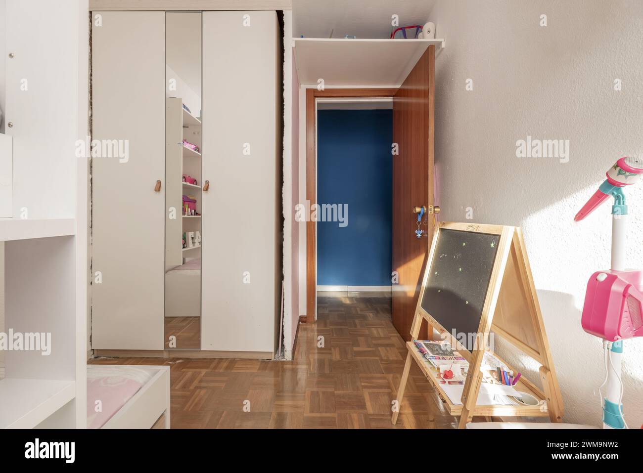 Bedroom with normal wooden wardrobe integrated into a hole in the wall ...