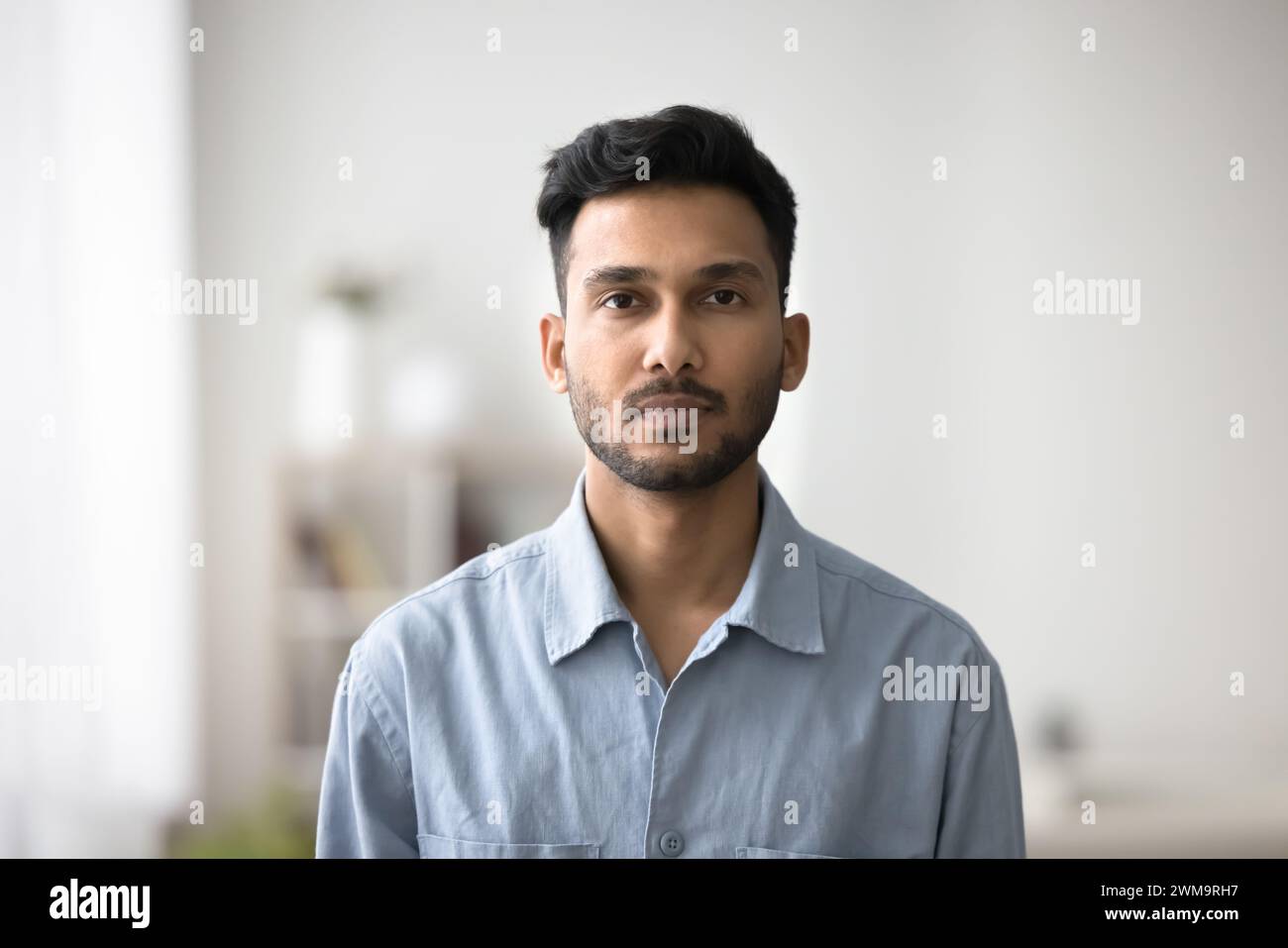 Serious Indian guy in casual blue shirt posing for camera Stock Photo ...