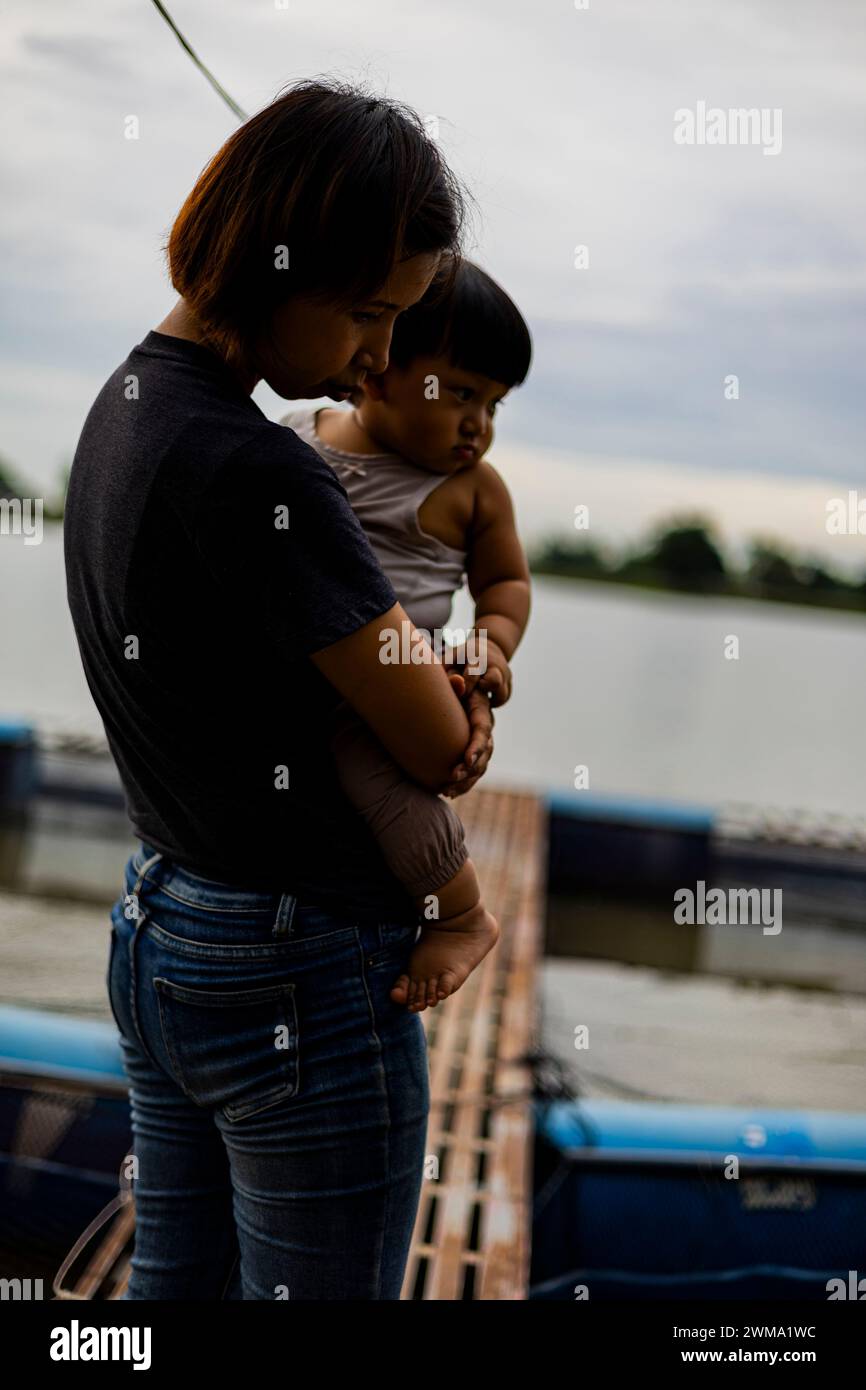 Mother and son watching fish in a pond of a fish farm Stock Photo - Alamy