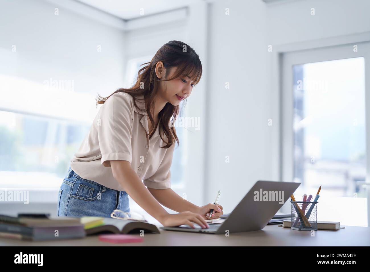 Young asian student in casual clothes watching tutorial and studying ...